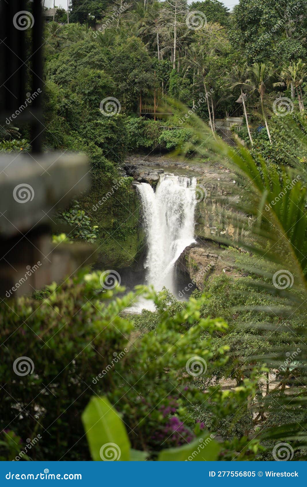 Large Waterfall Flowing Over The Top Of Lush Green Hillside Near