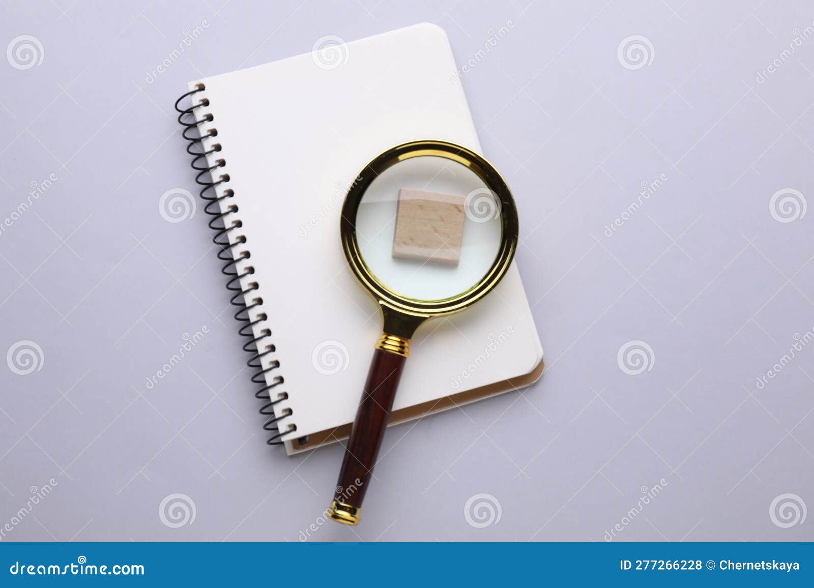 Magnifying Glass Over Piece of Wood and Notebook on Light Grey ...