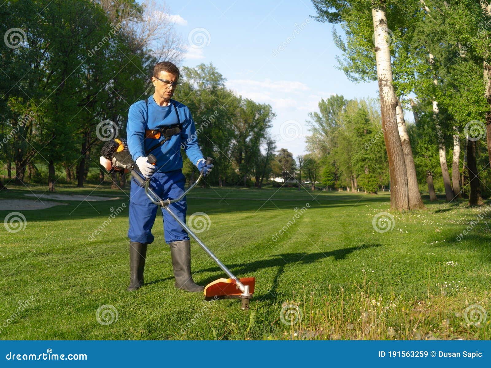The Worker Mows the Grass Using a Trimmer Image,maintenance the ...