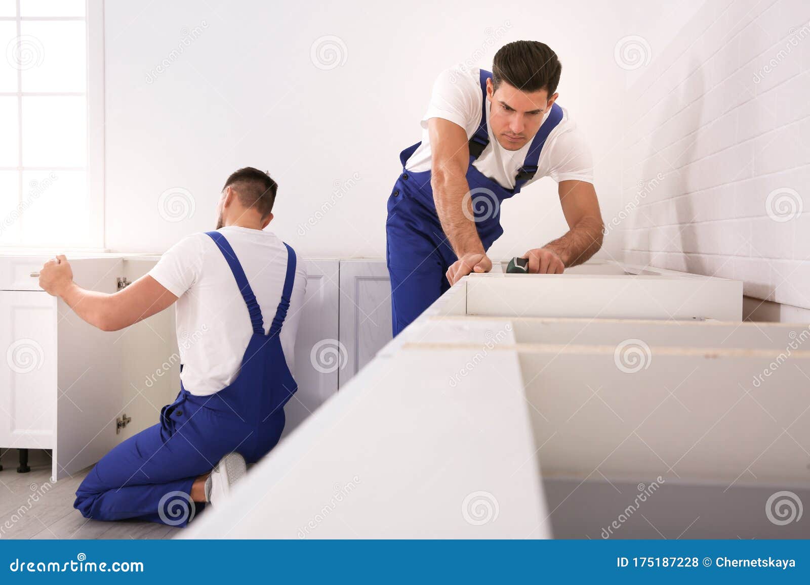 Maintenance Workers Installing New Kitchen Furniture Stock Photo ...
