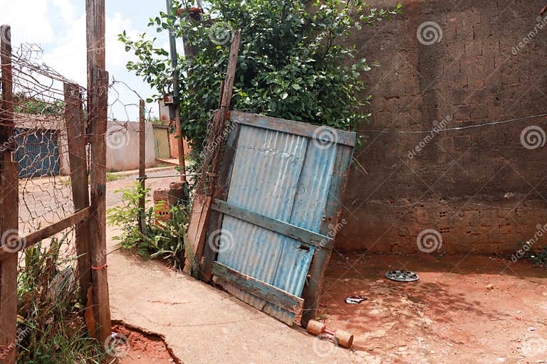 A Make Shift Fence and Gate in Front of a House that’s Falling Down ...