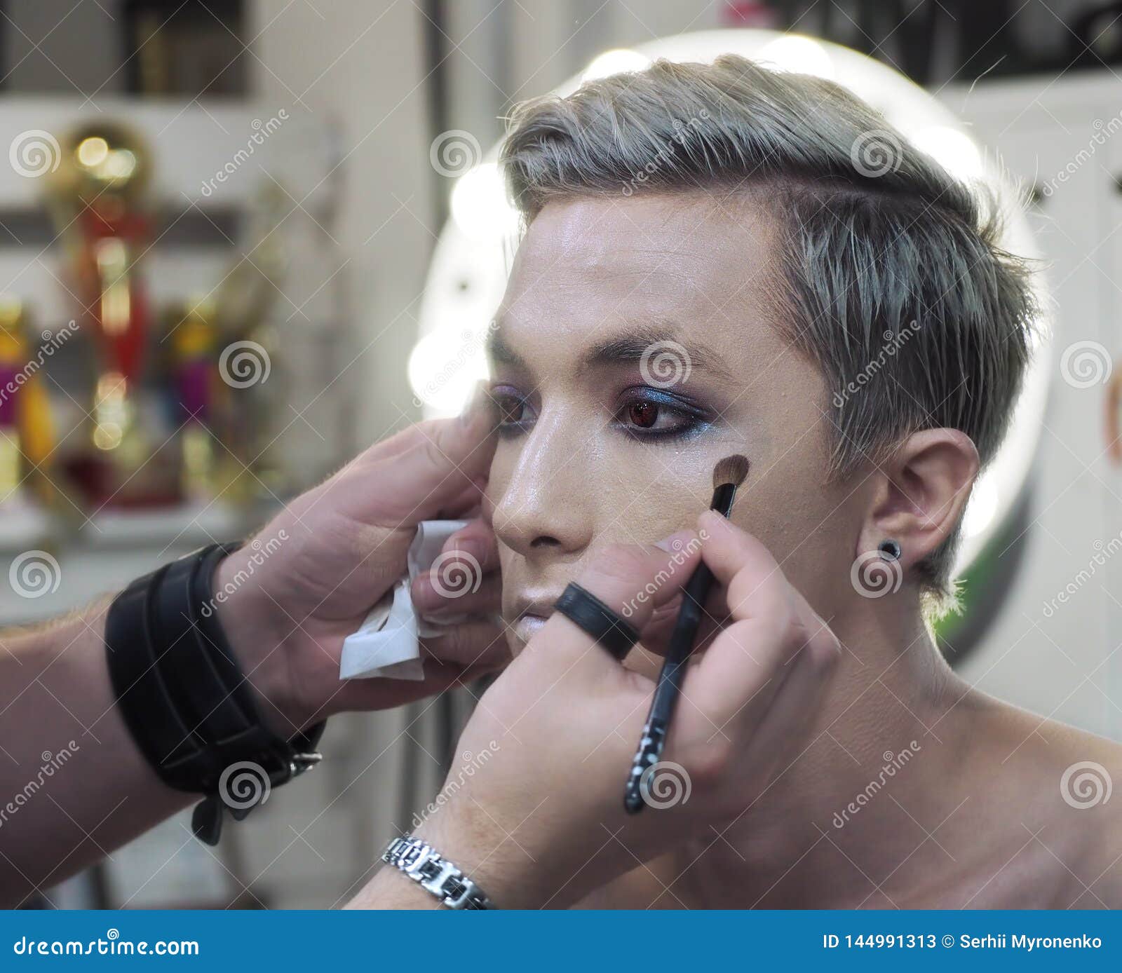 Make Up Artist Makes Make-up at the Young Male Model`s Cheek Stock ...