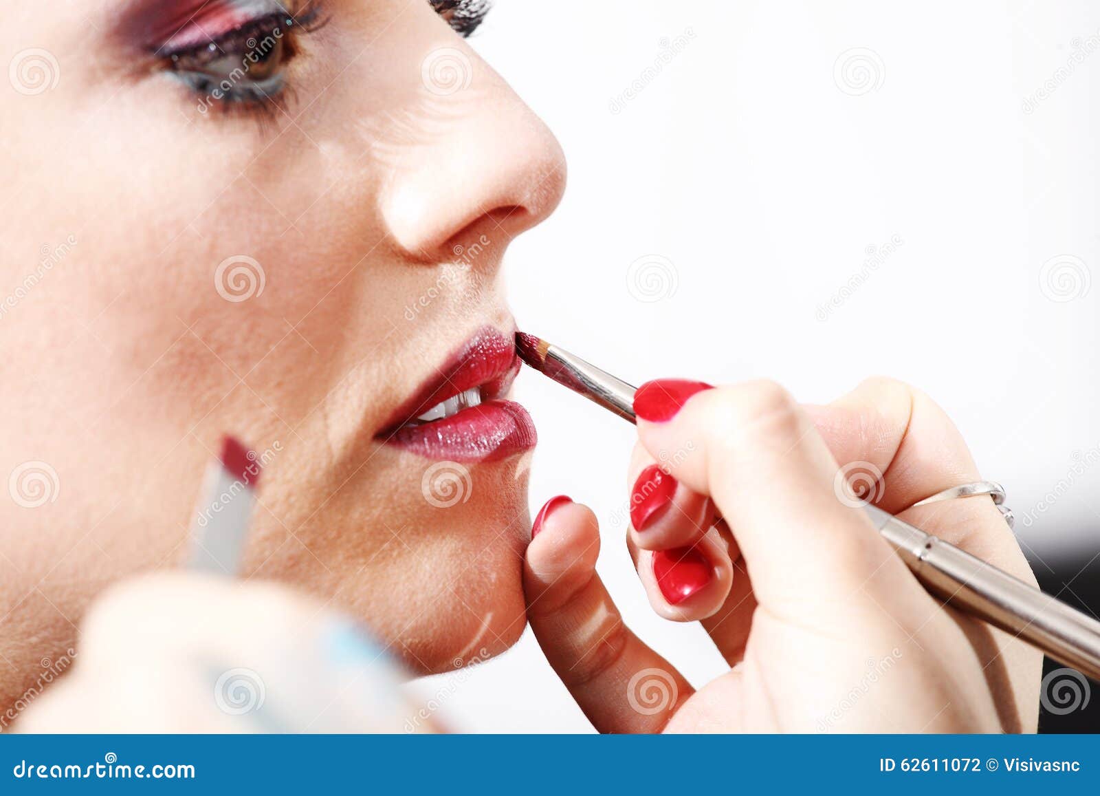 Makeup Artist Applying Lipstick on Model Lips with Brush Stock Photo ...