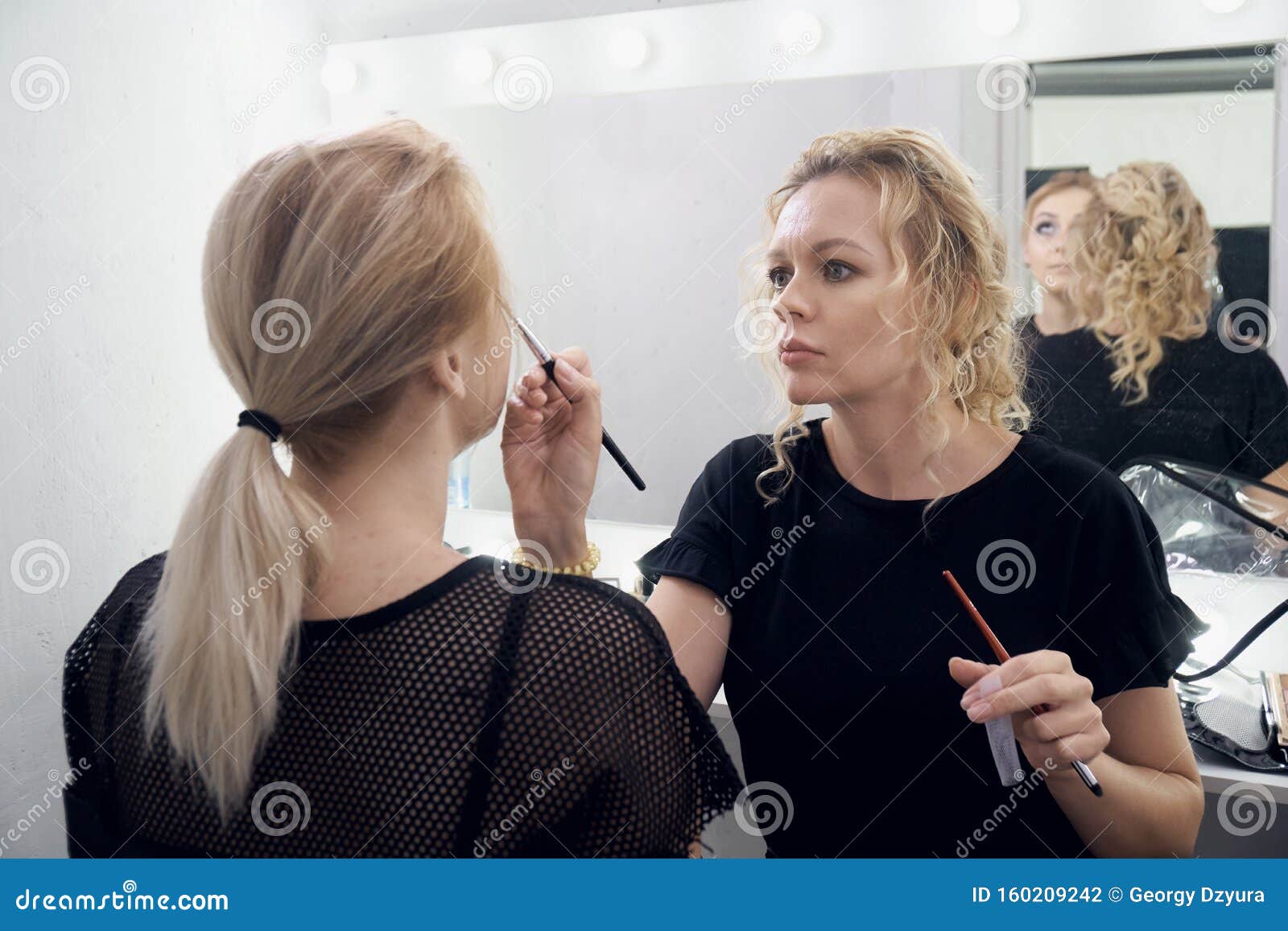Makeup Artist Doing a Makeup for a Young Model before a Photo Session ...