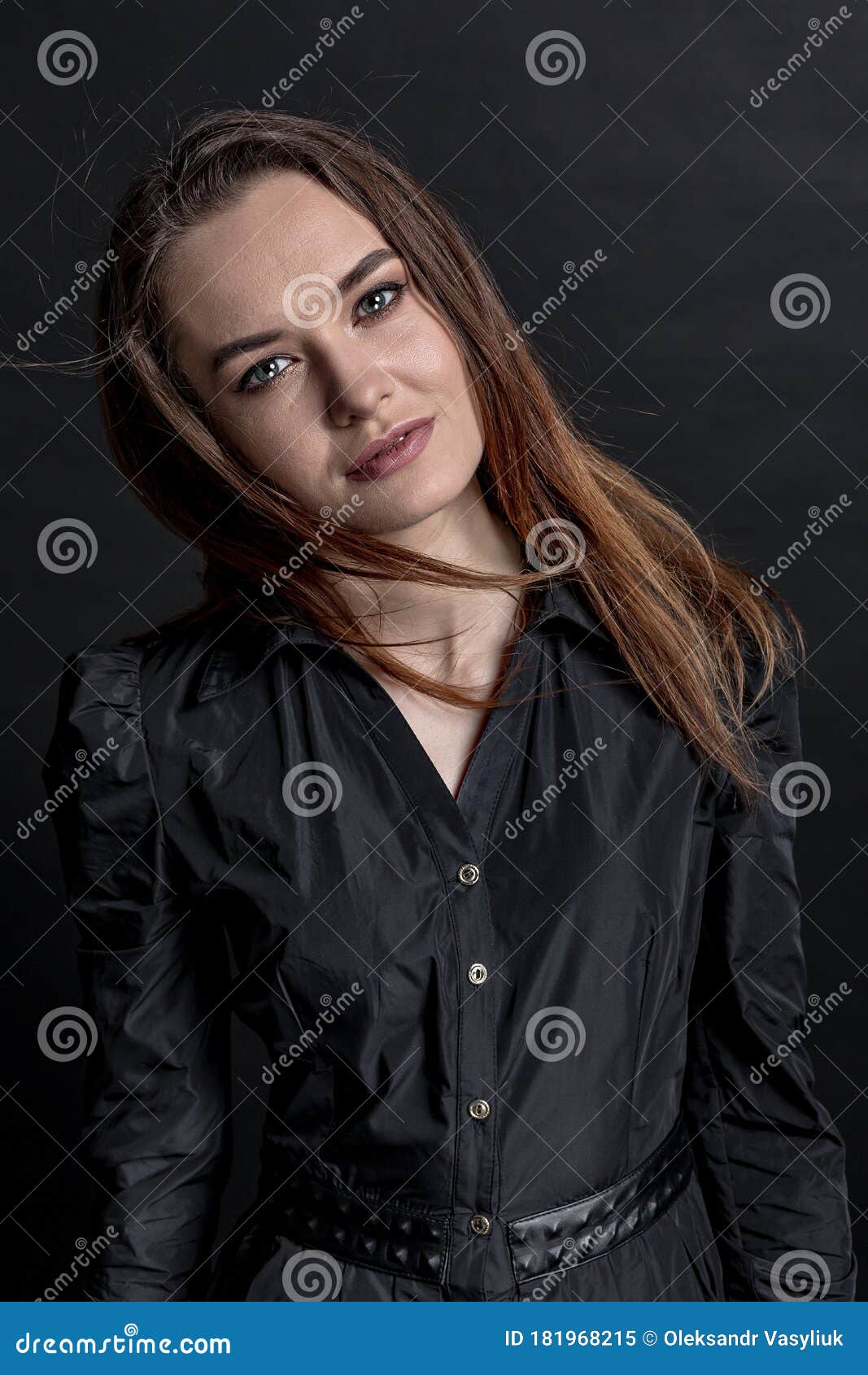 A Makeup Brunette Girl In A Black Dress Is Standing And Looking At The