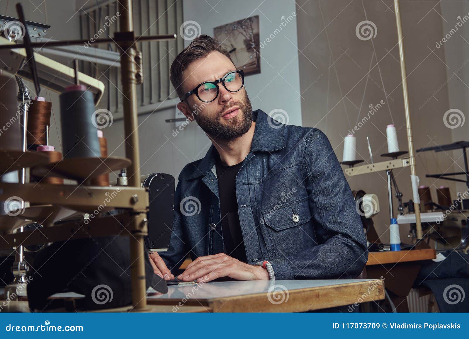 Making Clothes. Tailor Sitting at a Table and Working on a Sewing ...