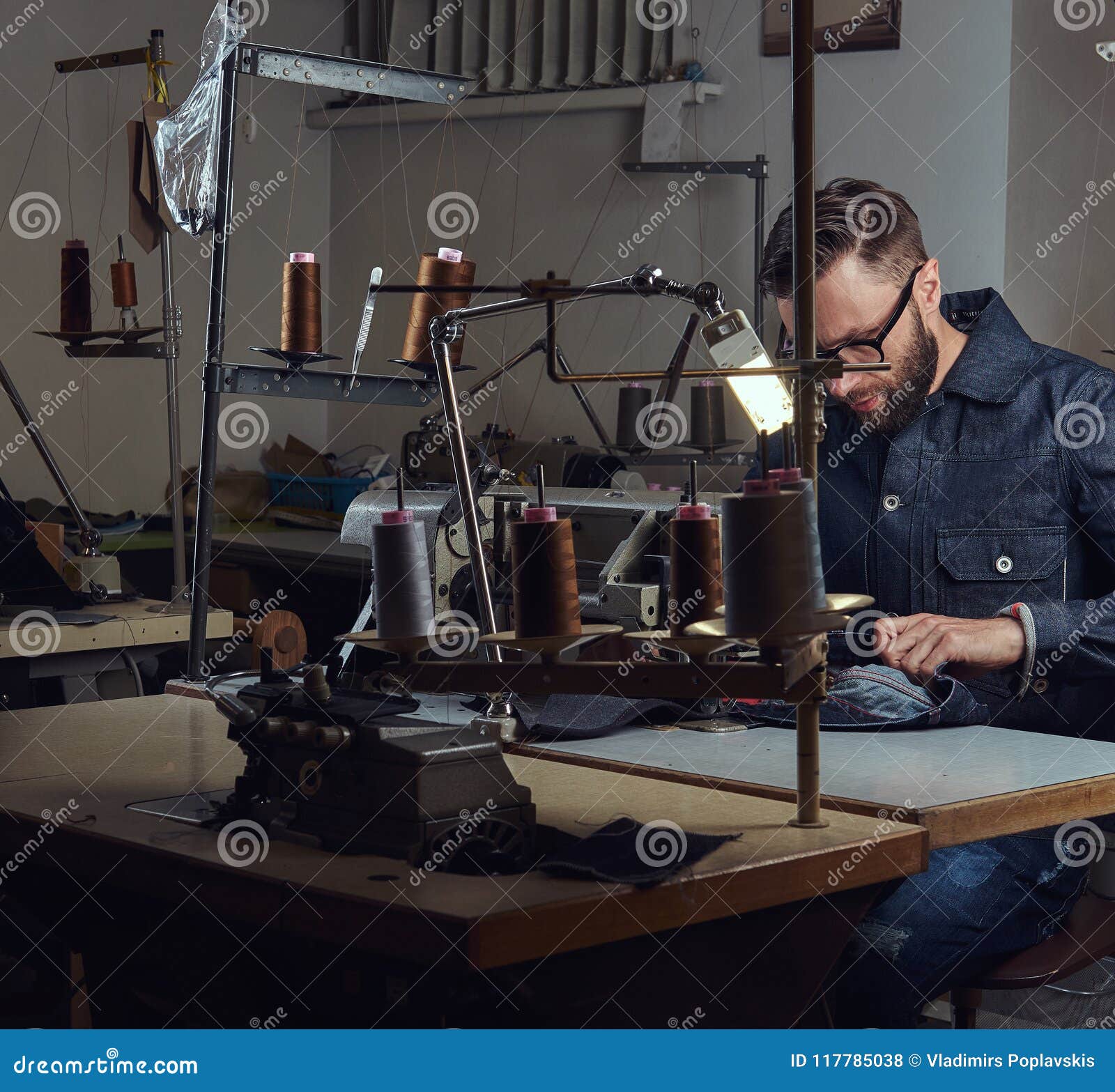 Making Clothes. Tailor Sitting at Table and Working on a Sewing Machine ...