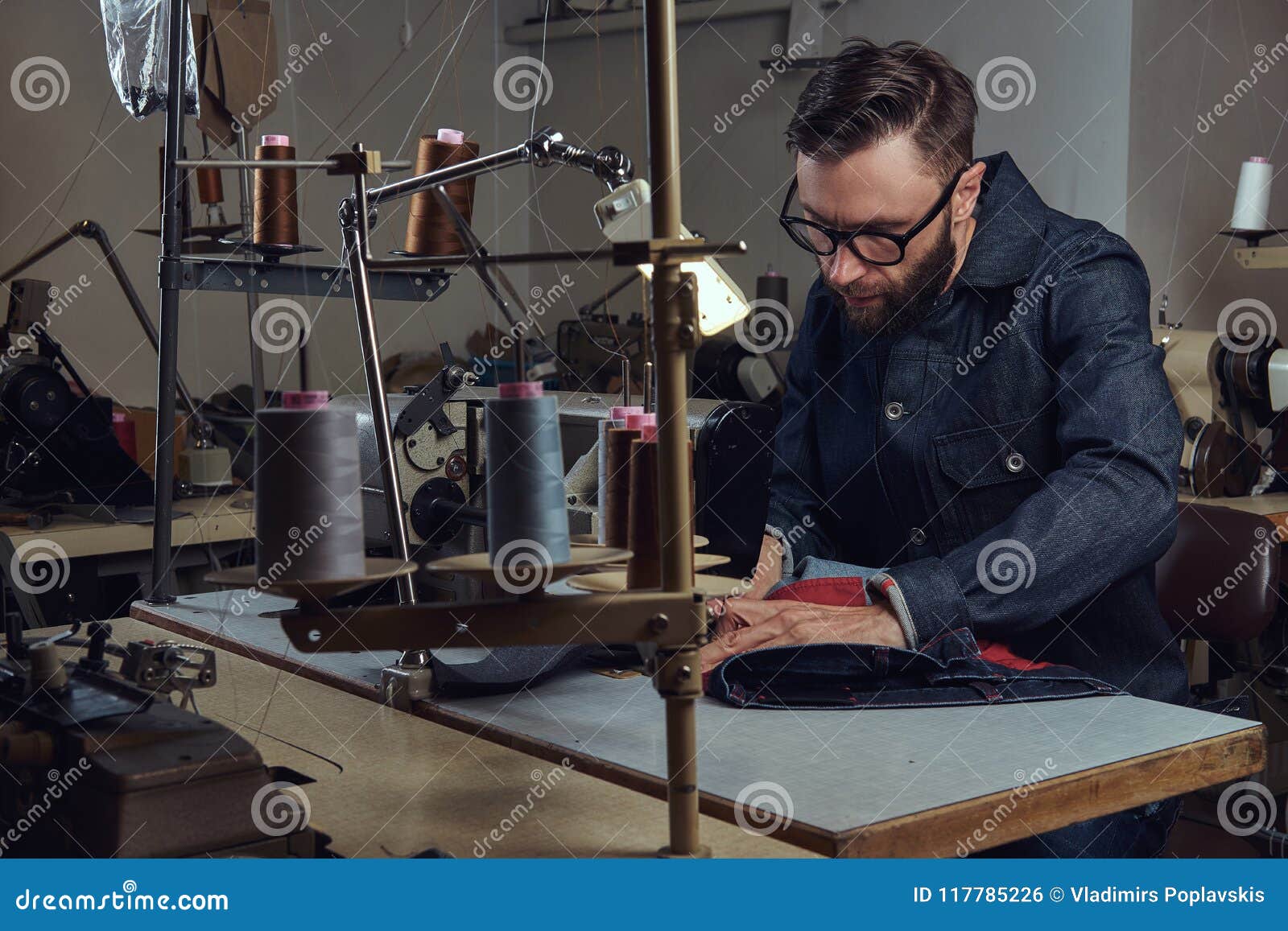 Making Clothes. Tailor Sitting at Table and Working on a Sewing Machine ...