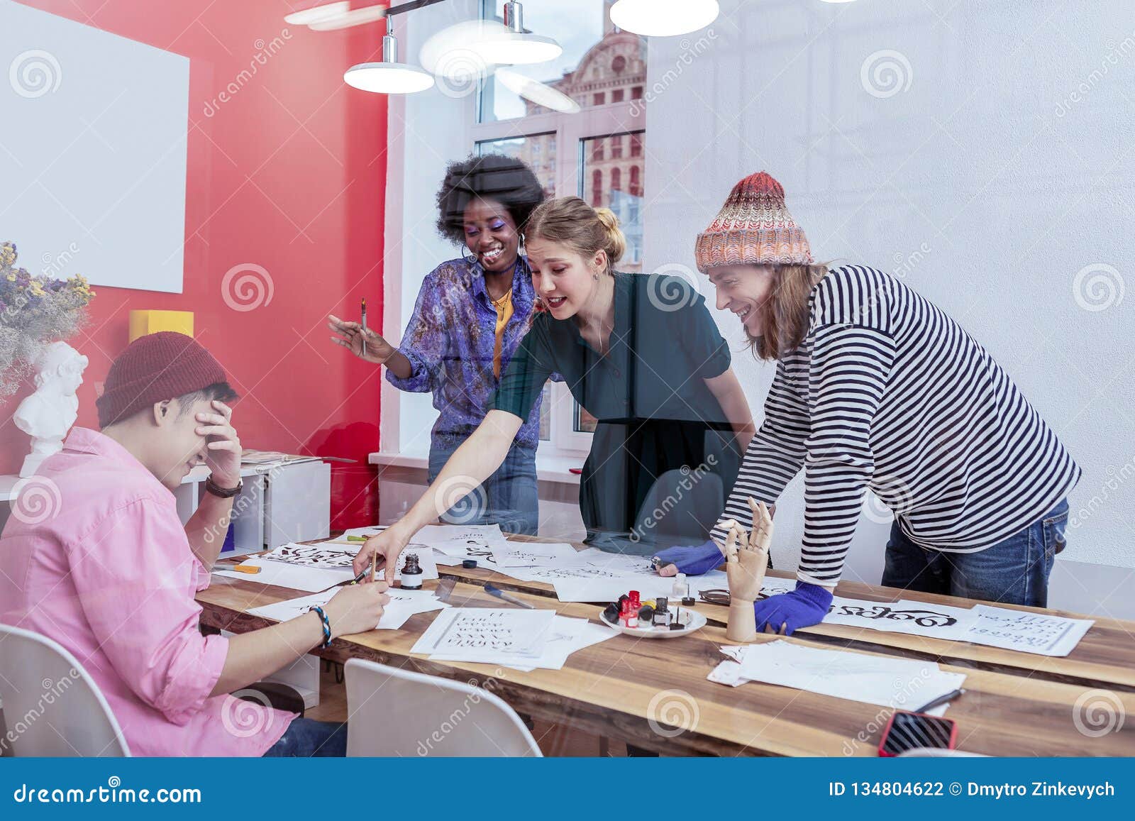 Three Creative Managers Making Fun of Their Young Colleague Stock Photo ...