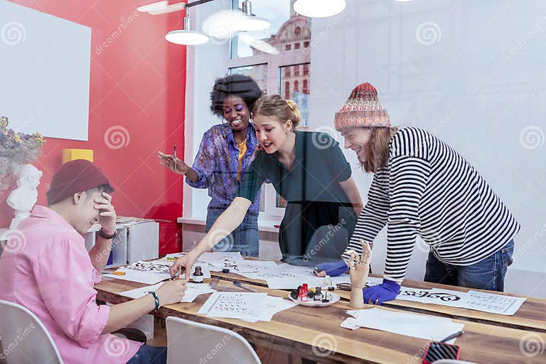 Three Creative Managers Making Fun of Their Young Colleague Stock Photo ...