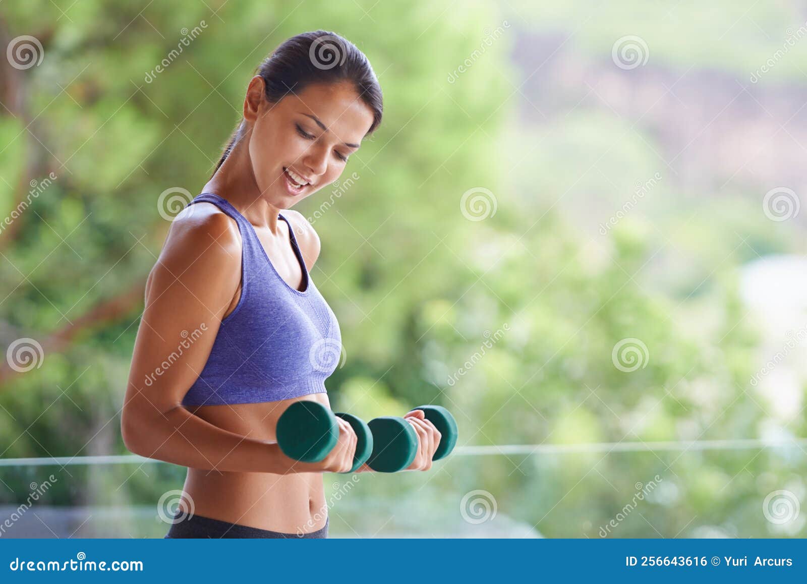 Making Good Progress. a Beautiful Young Woman Lifting Dumbbells ...