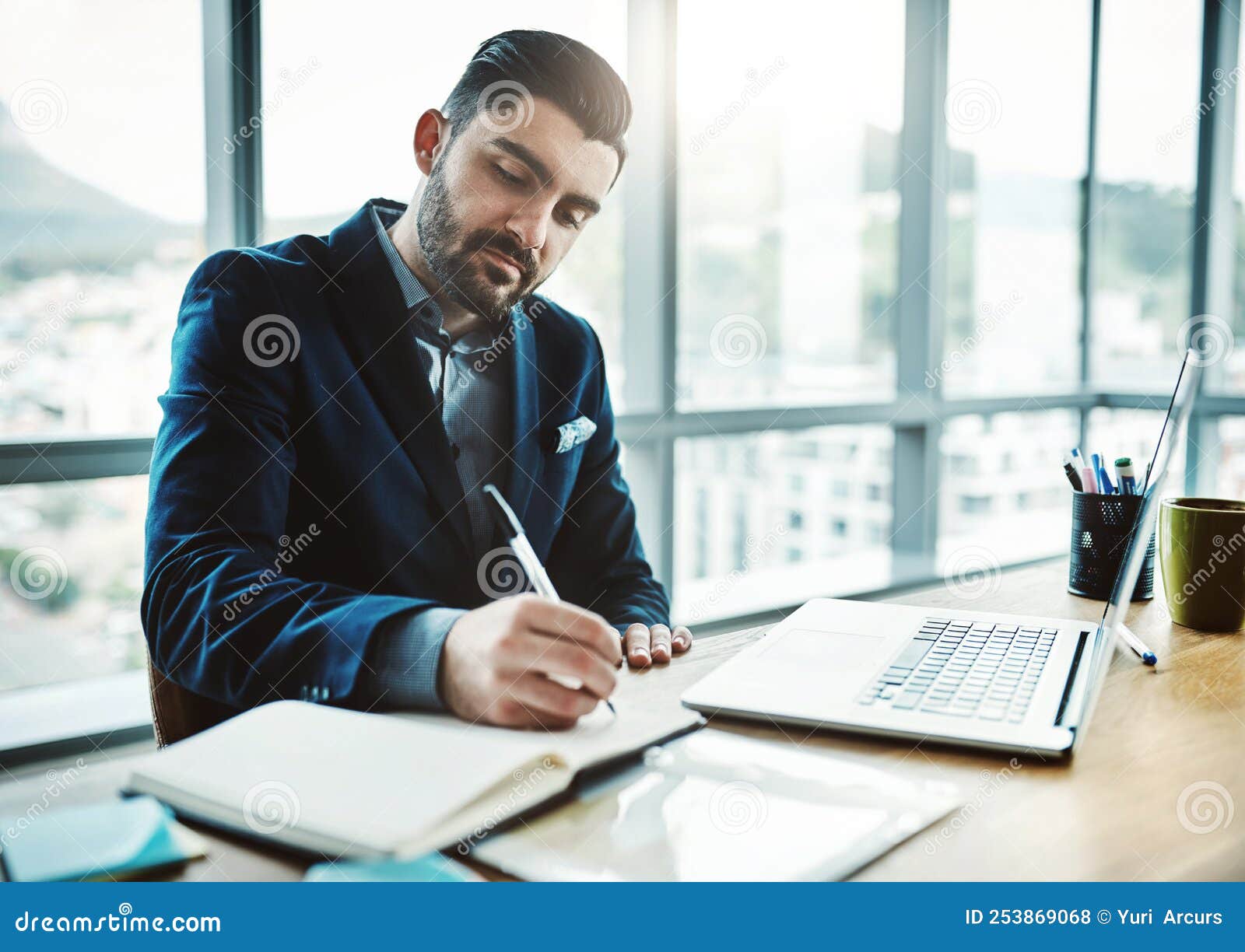 Making His daily Work Tasks Manageable. a Young Businessman Writing in ...