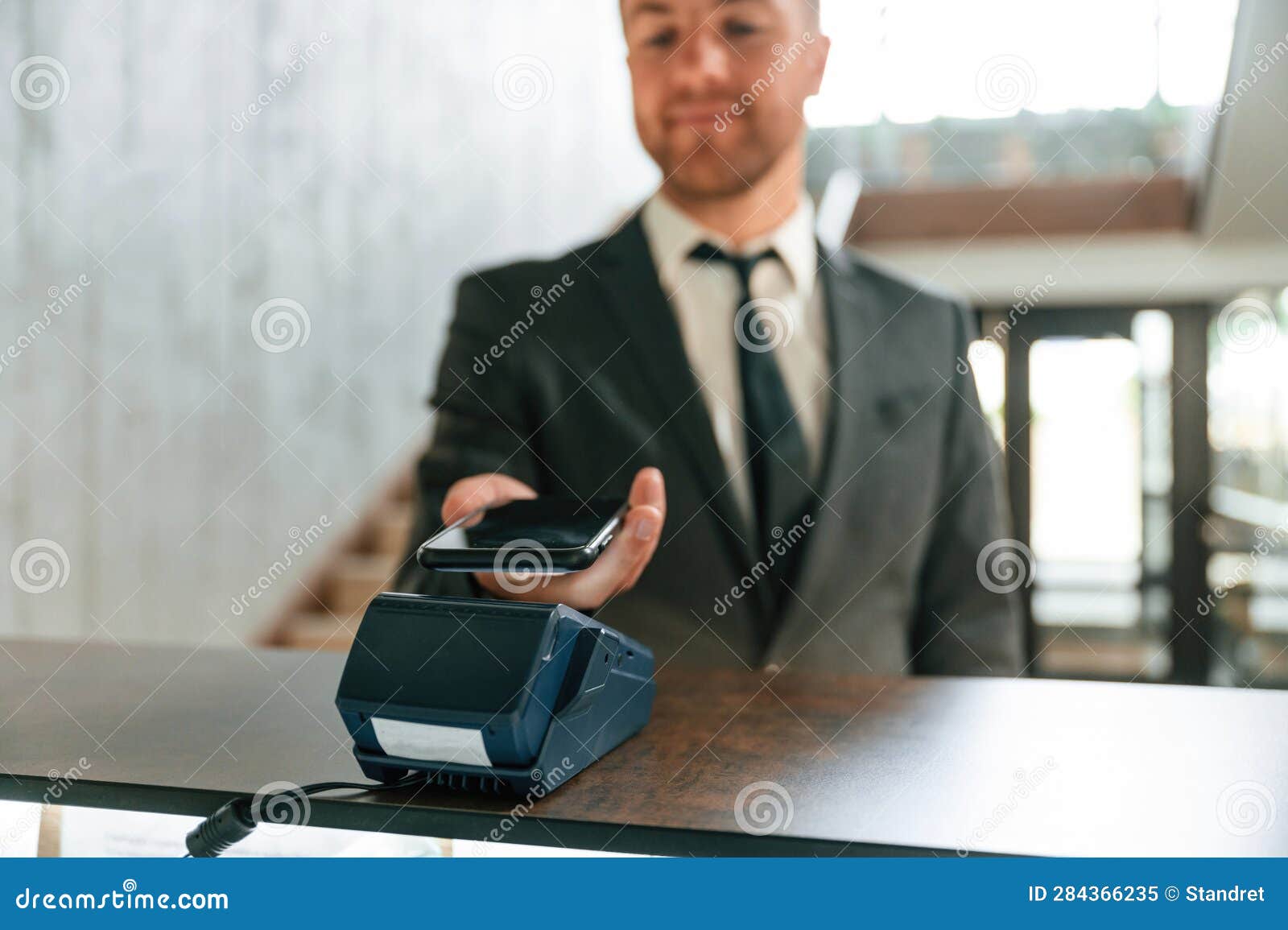 Making Payment by Using Phone and Terminal. a Man in a Black Jacket at ...
