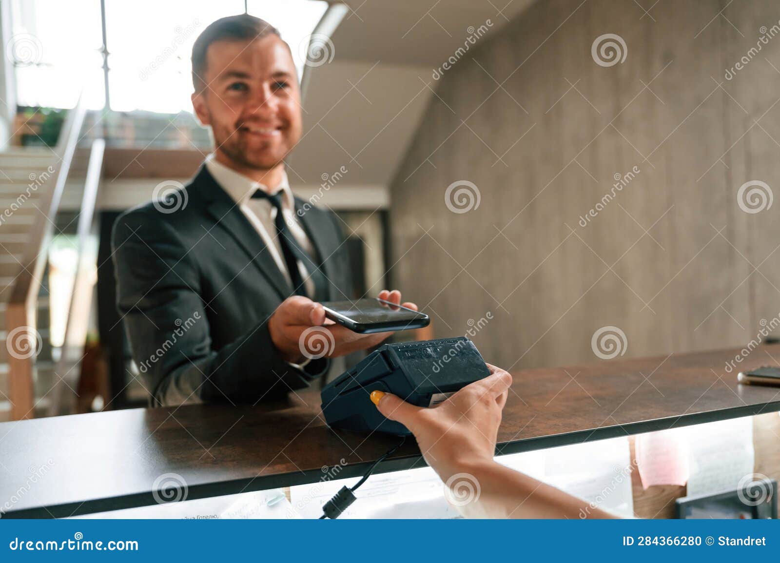 Making Payment by Using Phone and Terminal. a Man in a Black Jacket at ...
