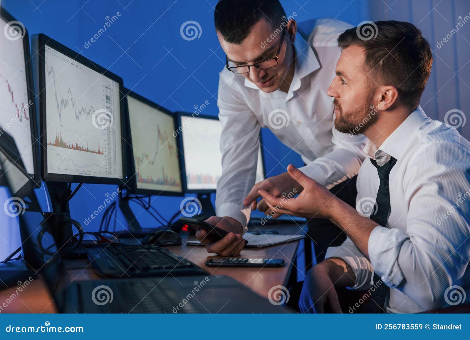 Making Profit. Two Stock Traders Working in the Office with Exchange ...