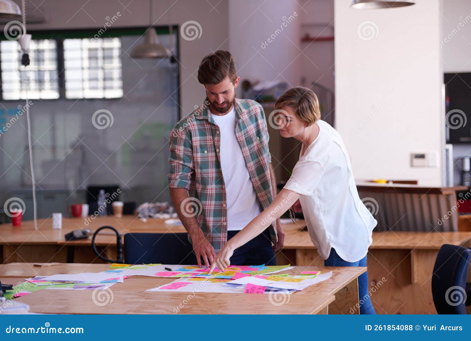 Making the Project Work for Them. a Young Woman Looking at Sticky Notes ...