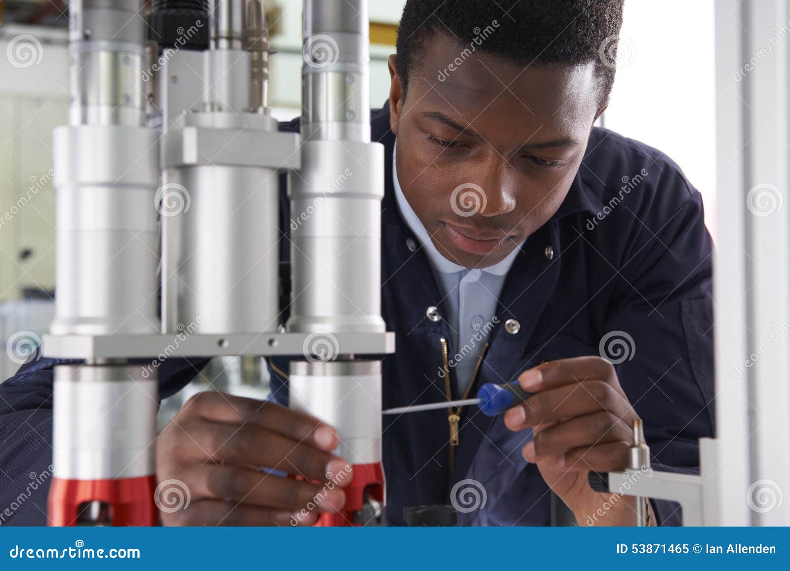 Male Apprentice Engineer Working on Machine in Factory Stock Image ...