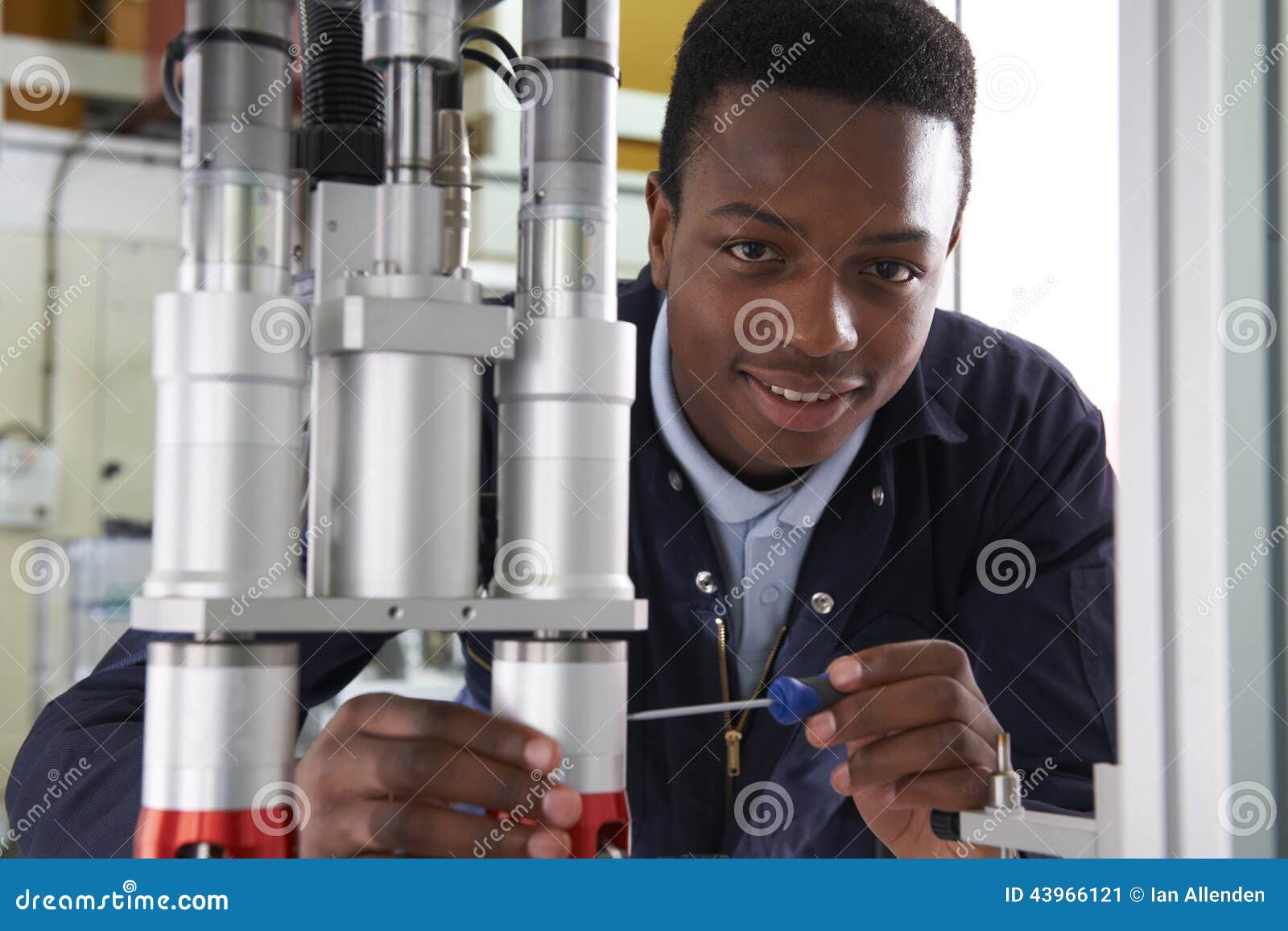 Male Apprentice Engineer Working on Machine in Factory Stock Image ...