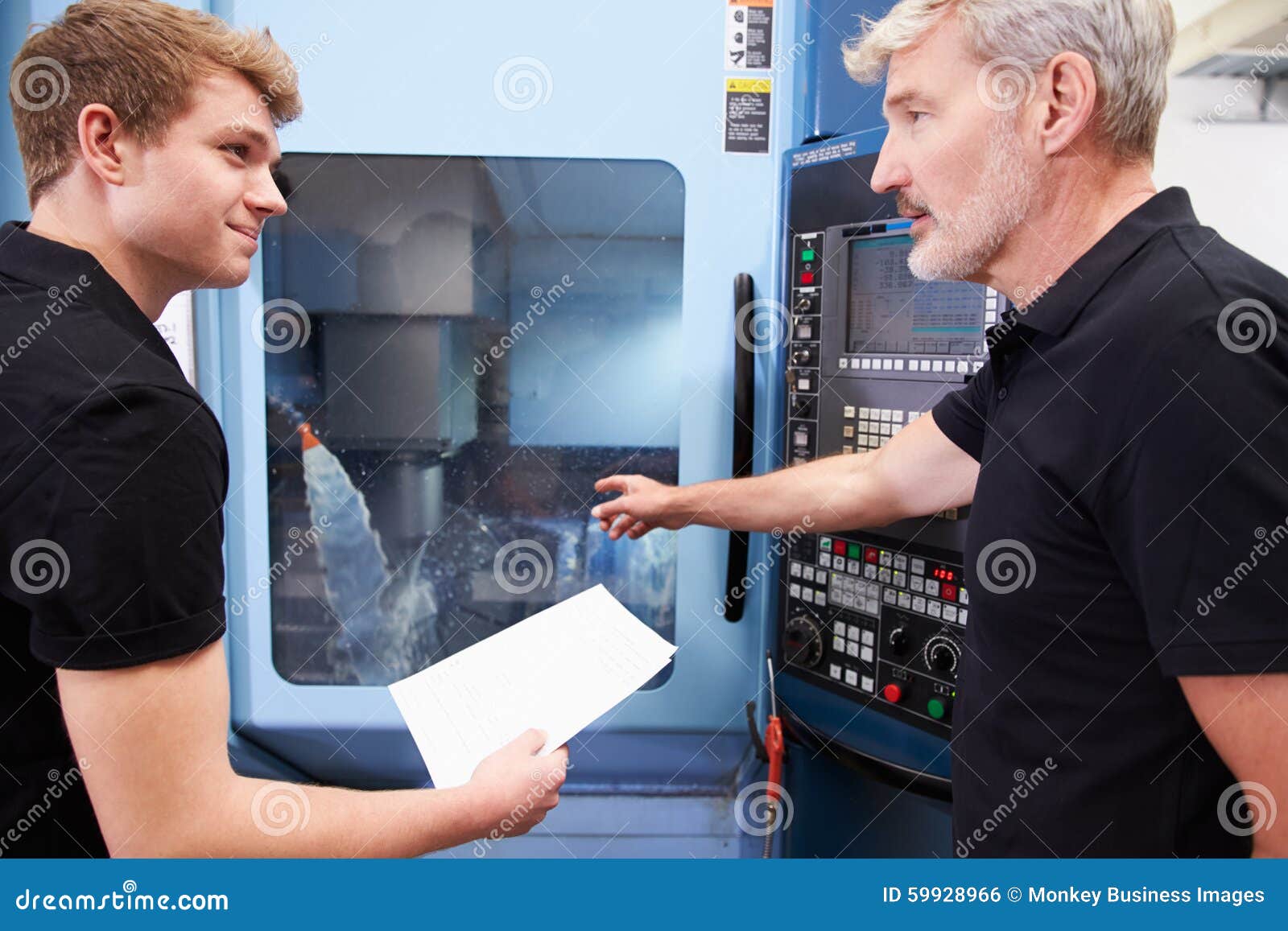Male Apprentice Working with Engineer on CNC Machinery Stock Photo ...