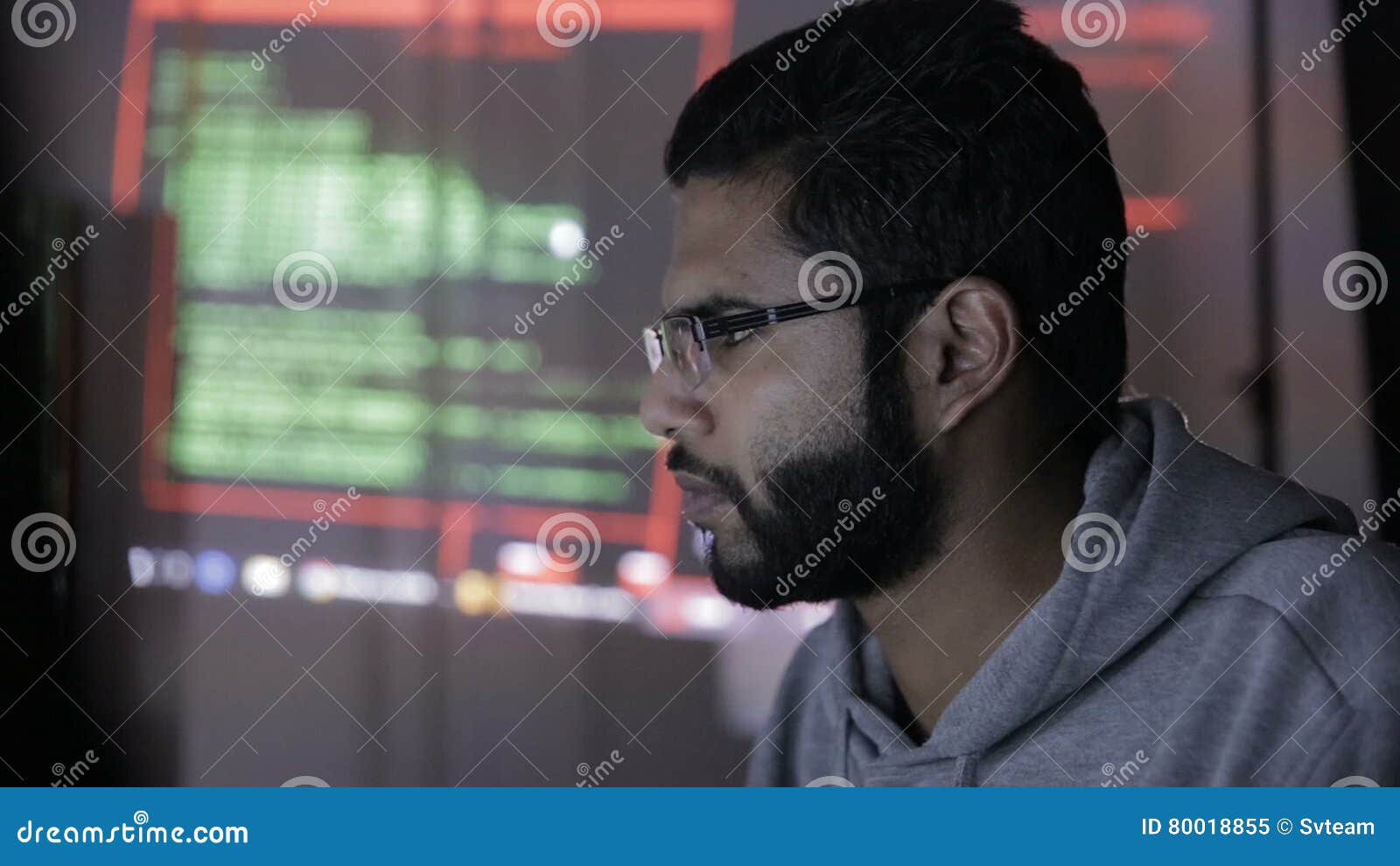 Male Arabic Hacker Hacks Computer in Dark. Computer Code Reflecting on ...