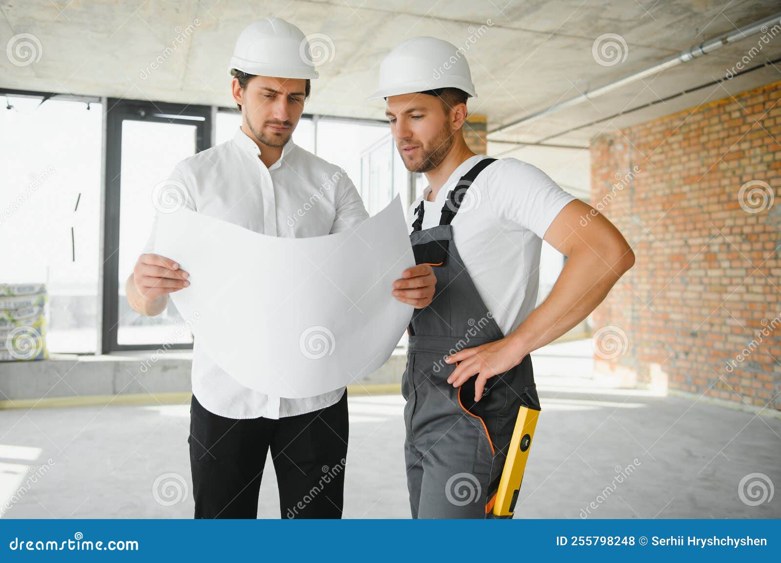 Male Architect Giving Instructions To His Foreman at Construction Site ...