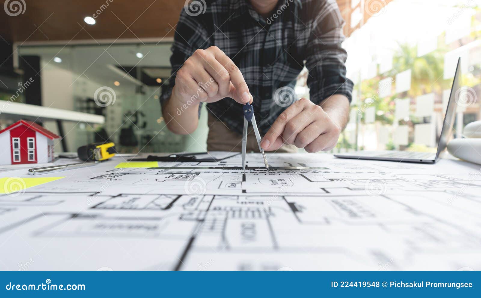 A Male Architect Using Compasses Measuring and Marking the Scale Ratio ...