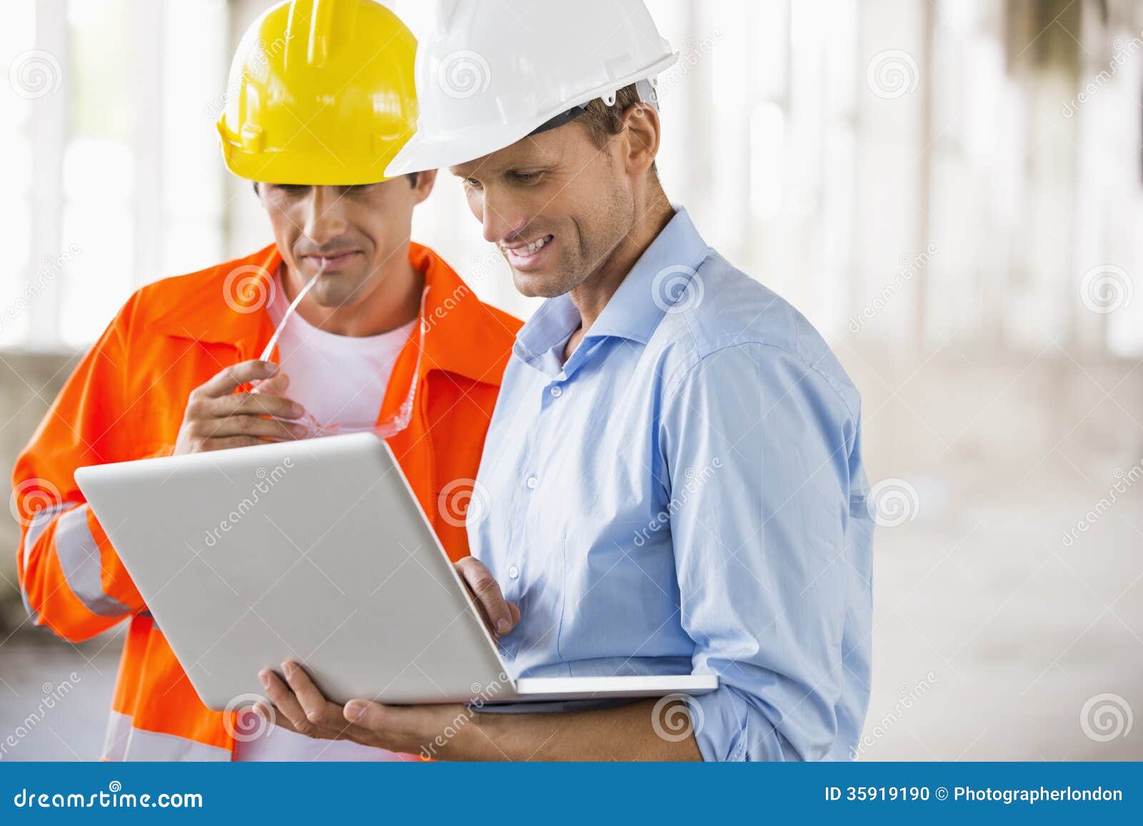 Male Architects Working on Laptop at Construction Site Stock Photo ...