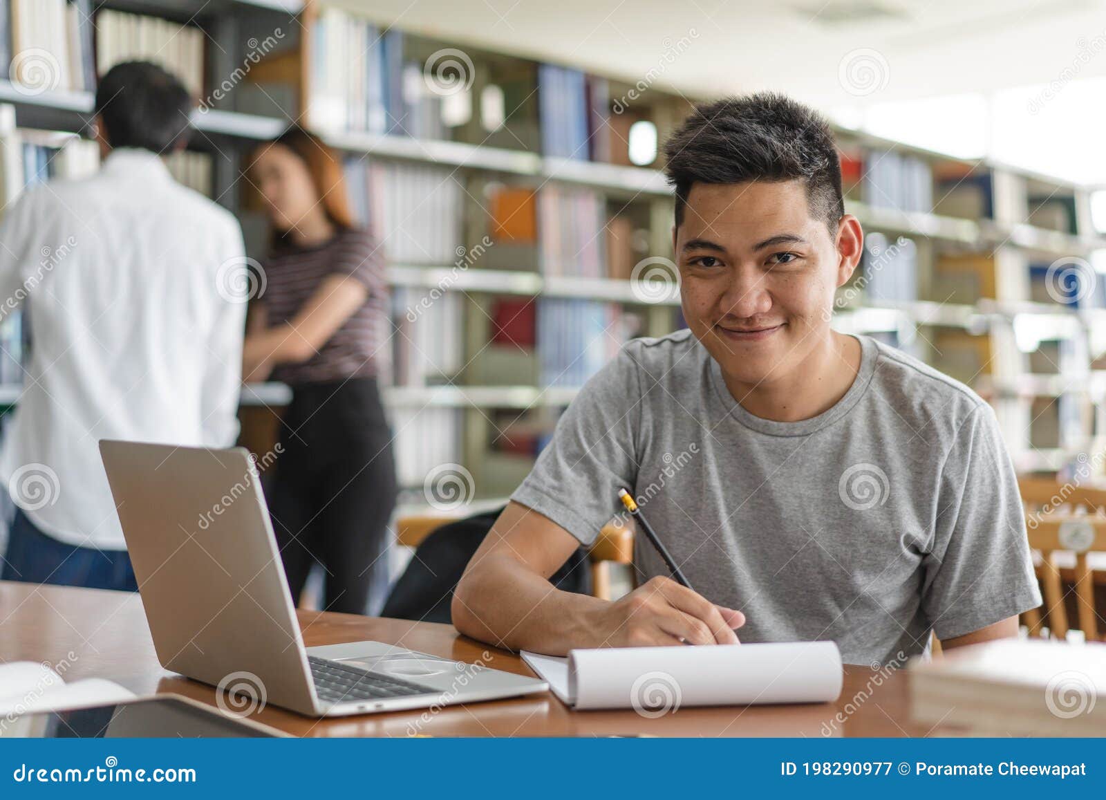 Male Asian Student Studying and Reading Book in Library Stock Image ...