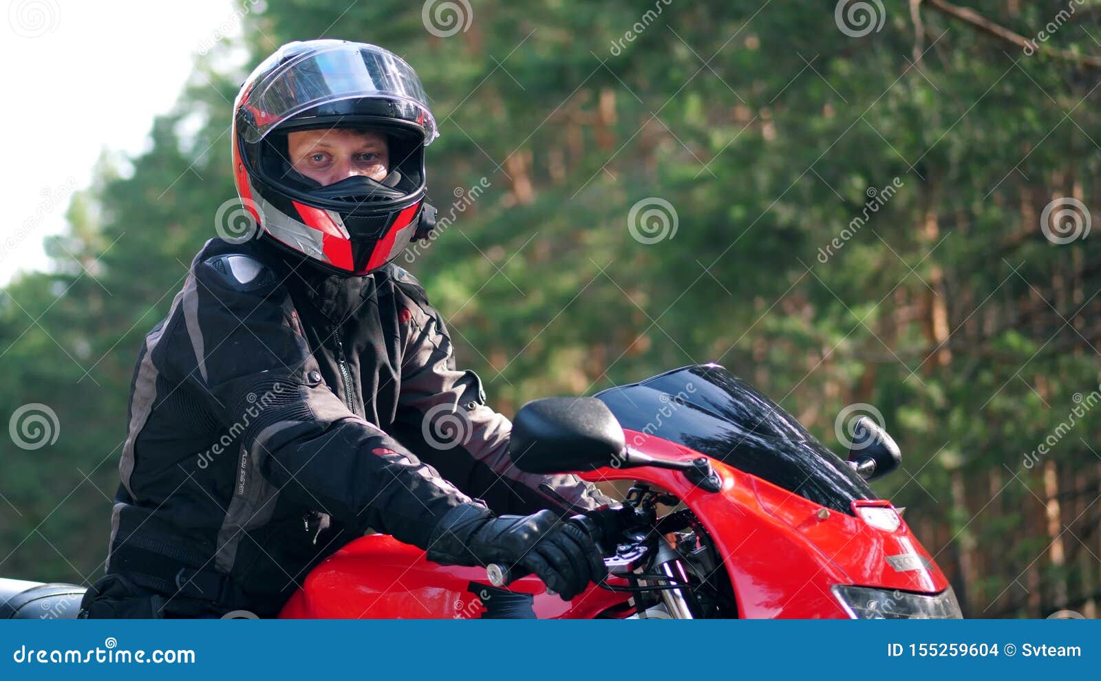 Male Biker in Helmet Sits on a Motorcycle, Looking at Camera. Stock ...