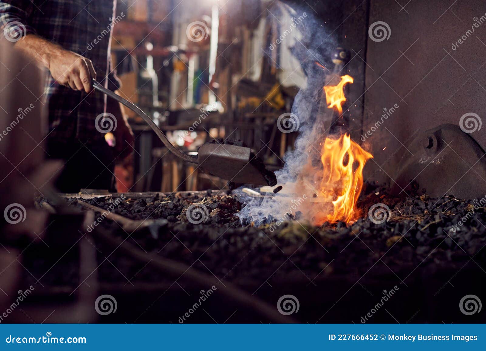 Male Blacksmith Adding Coal Fuel To Wood Kindling To Start Blaze in ...