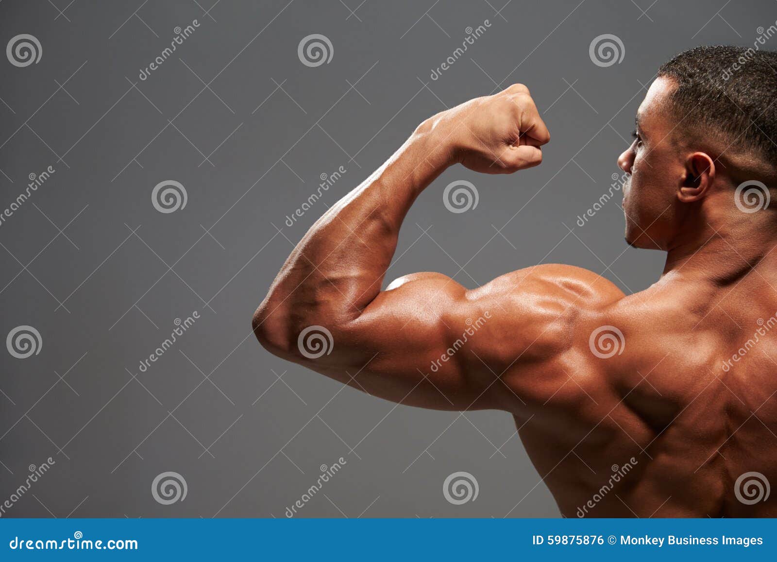 Male Bodybuilder Flexing Bicep, Back View with Copy Space Stock Photo ...