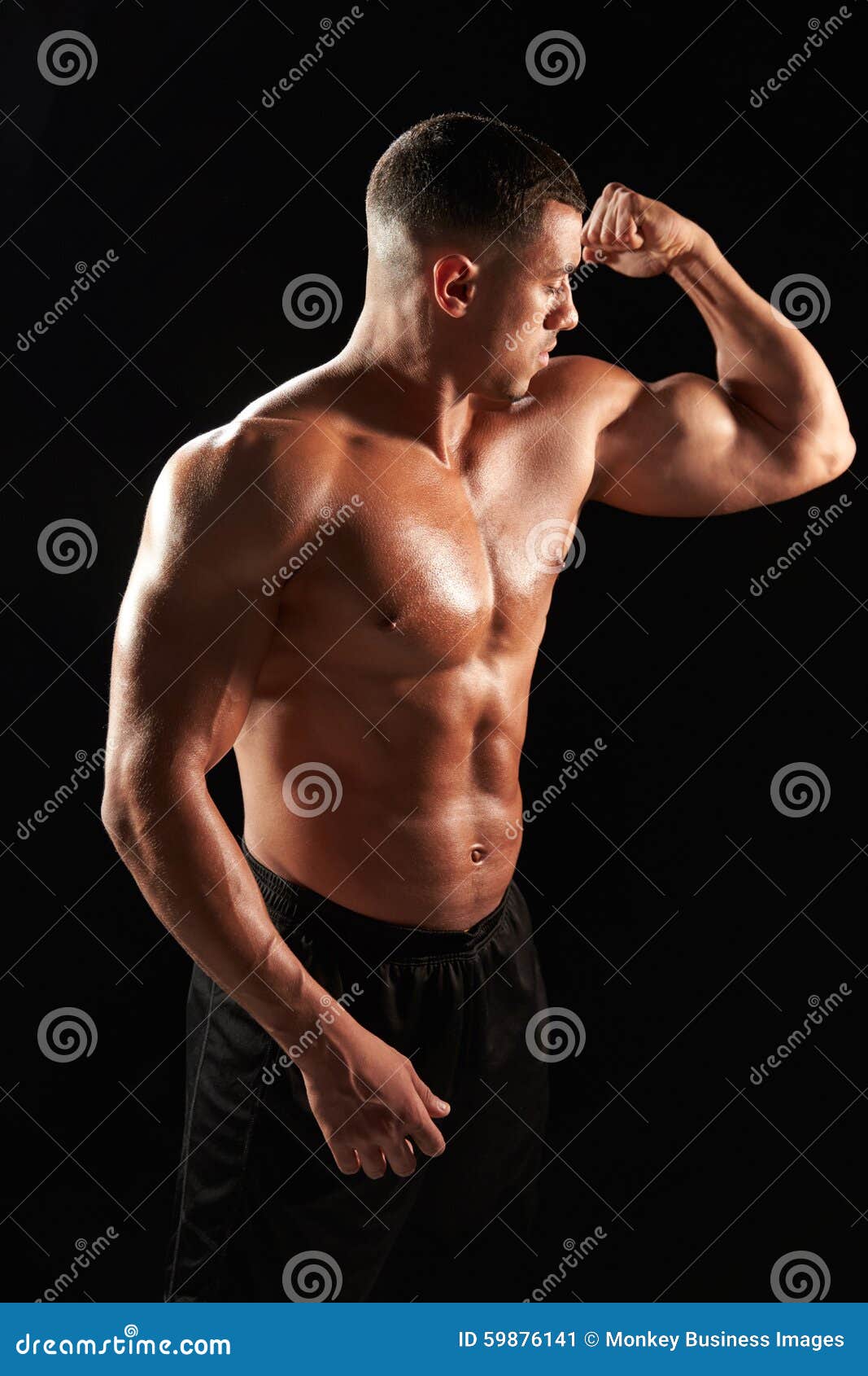 Male Bodybuilder Looking at His Flexing Muscles Stock Image - Image of ...