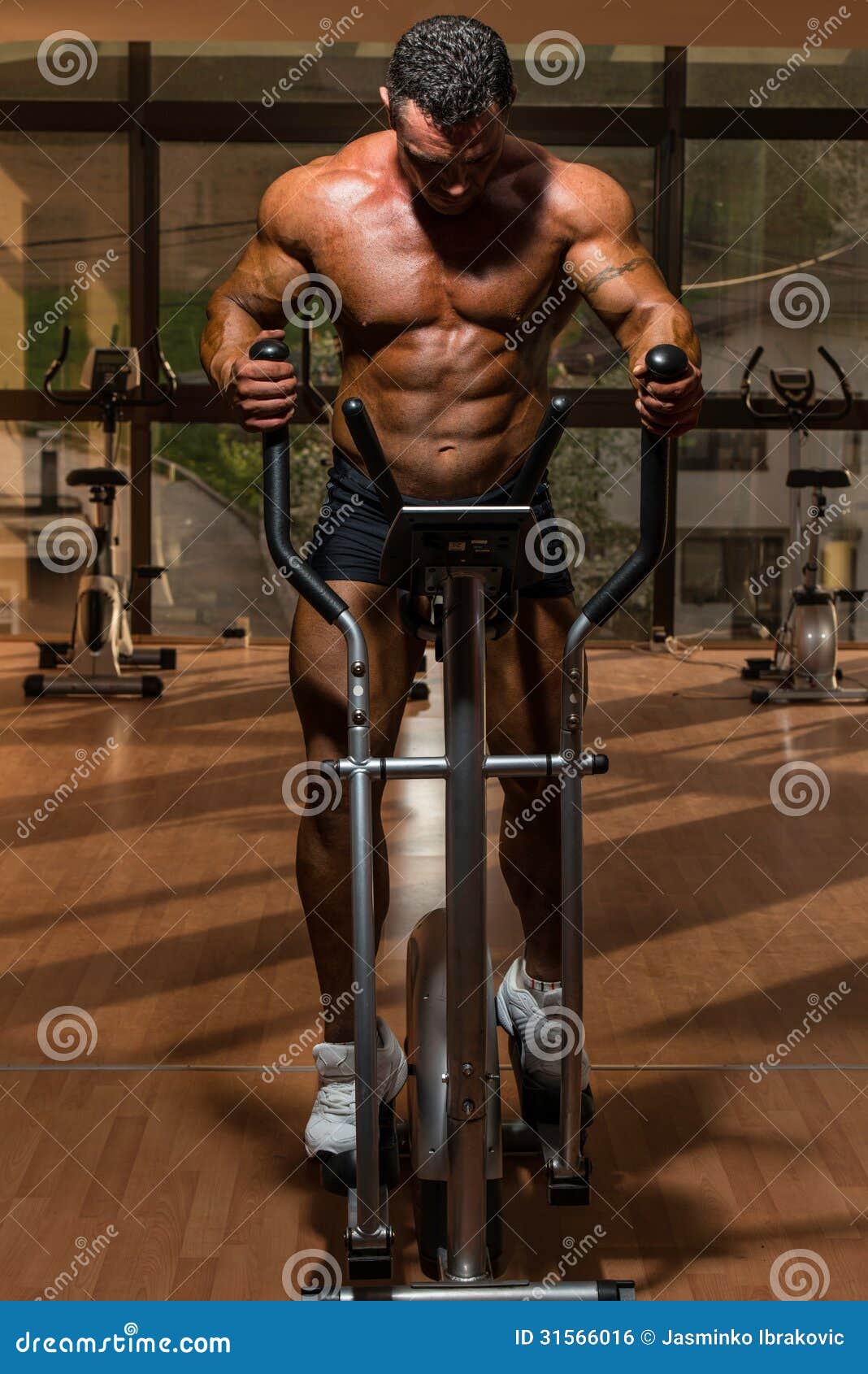 Male Bodybuilder Using the Elliptical Machine Stock Photo - Image of ...