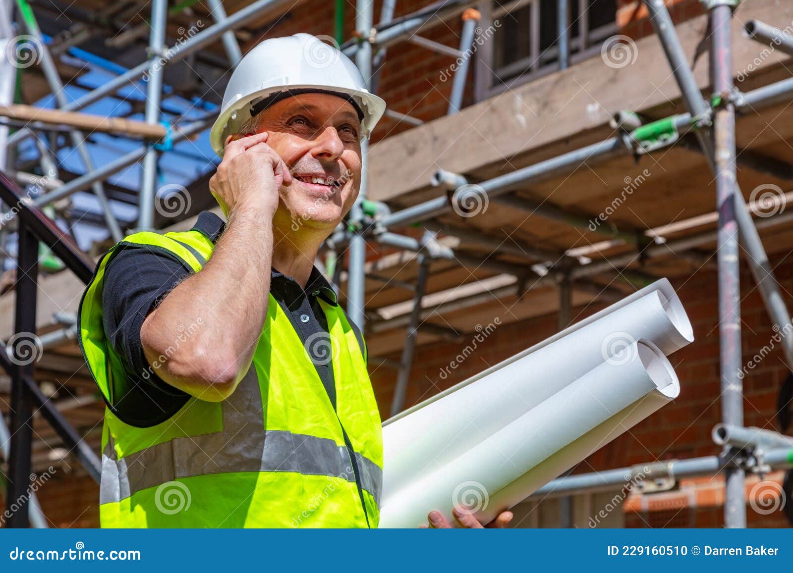 Male Builder Construction Worker on Building Site Using Cell Phone and ...