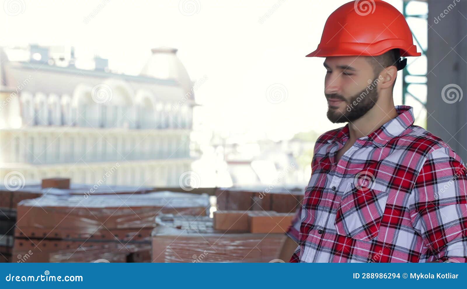Male Builder Corrects His Hard Hat at the Building Under Construction ...