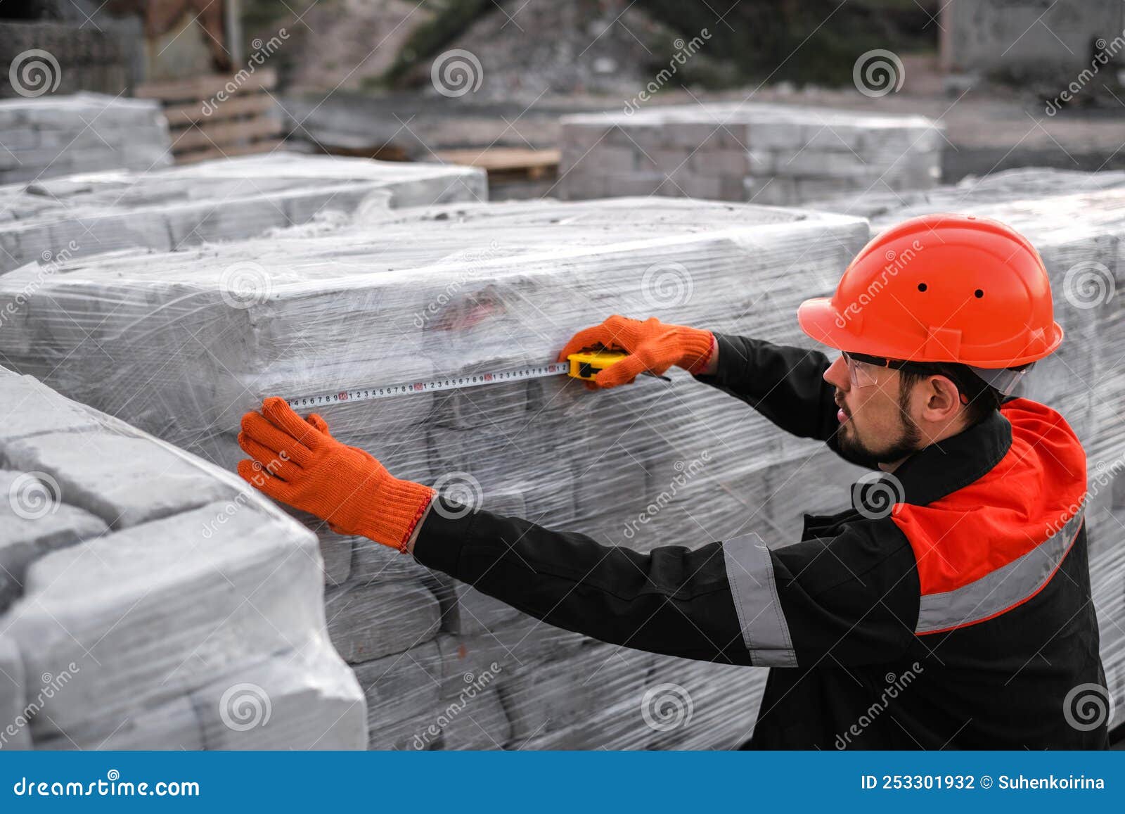 Male Builder Measures the Size of Brick Pallets at a Construction Site ...
