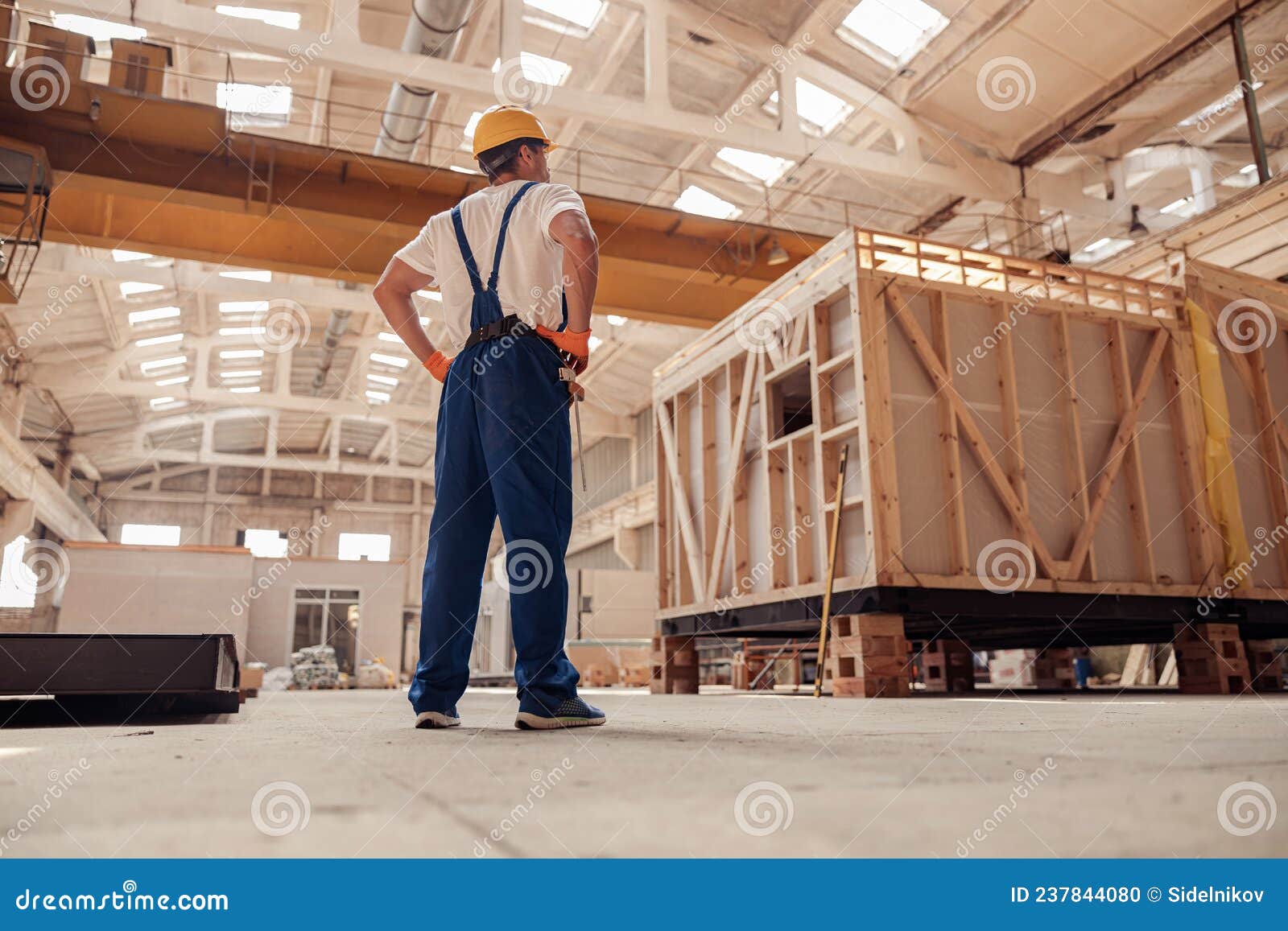 Male Builder in Work Overalls Observing Building Under Construction ...
