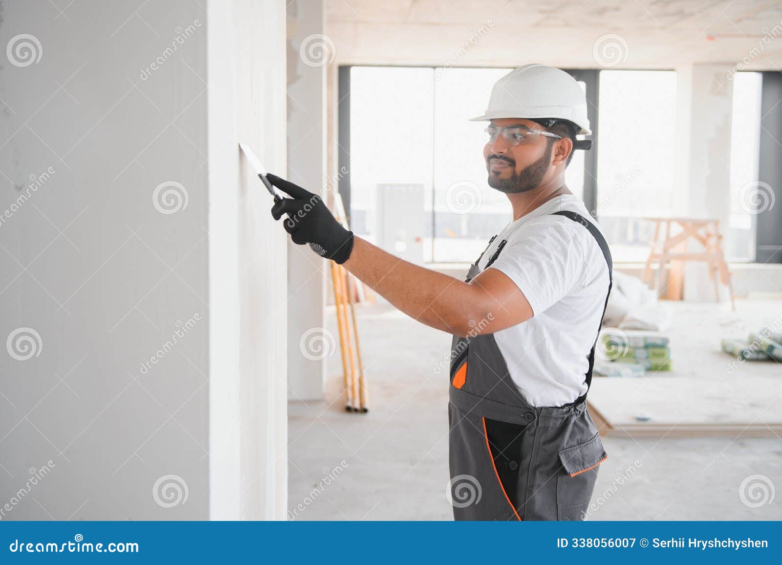 Indian Male Builder in Work Overalls Plastering a Wall Using a ...