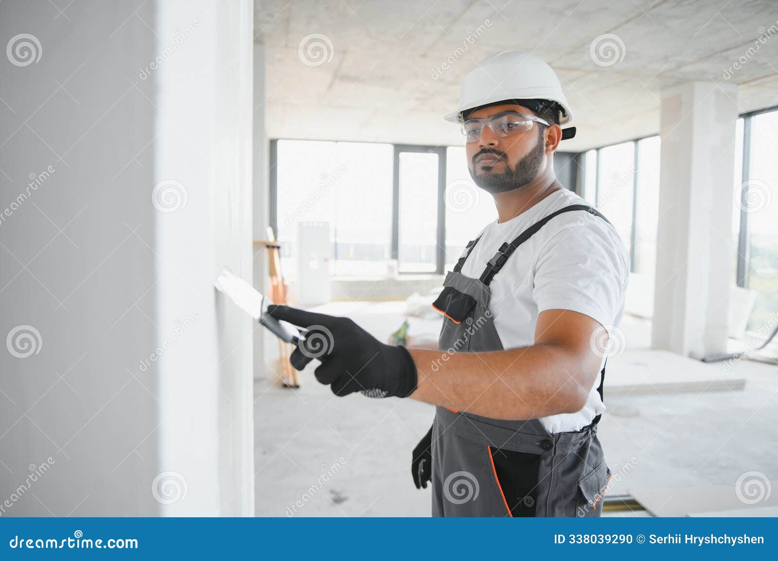 Indian Male Builder in Work Overalls Plastering a Wall Using a ...