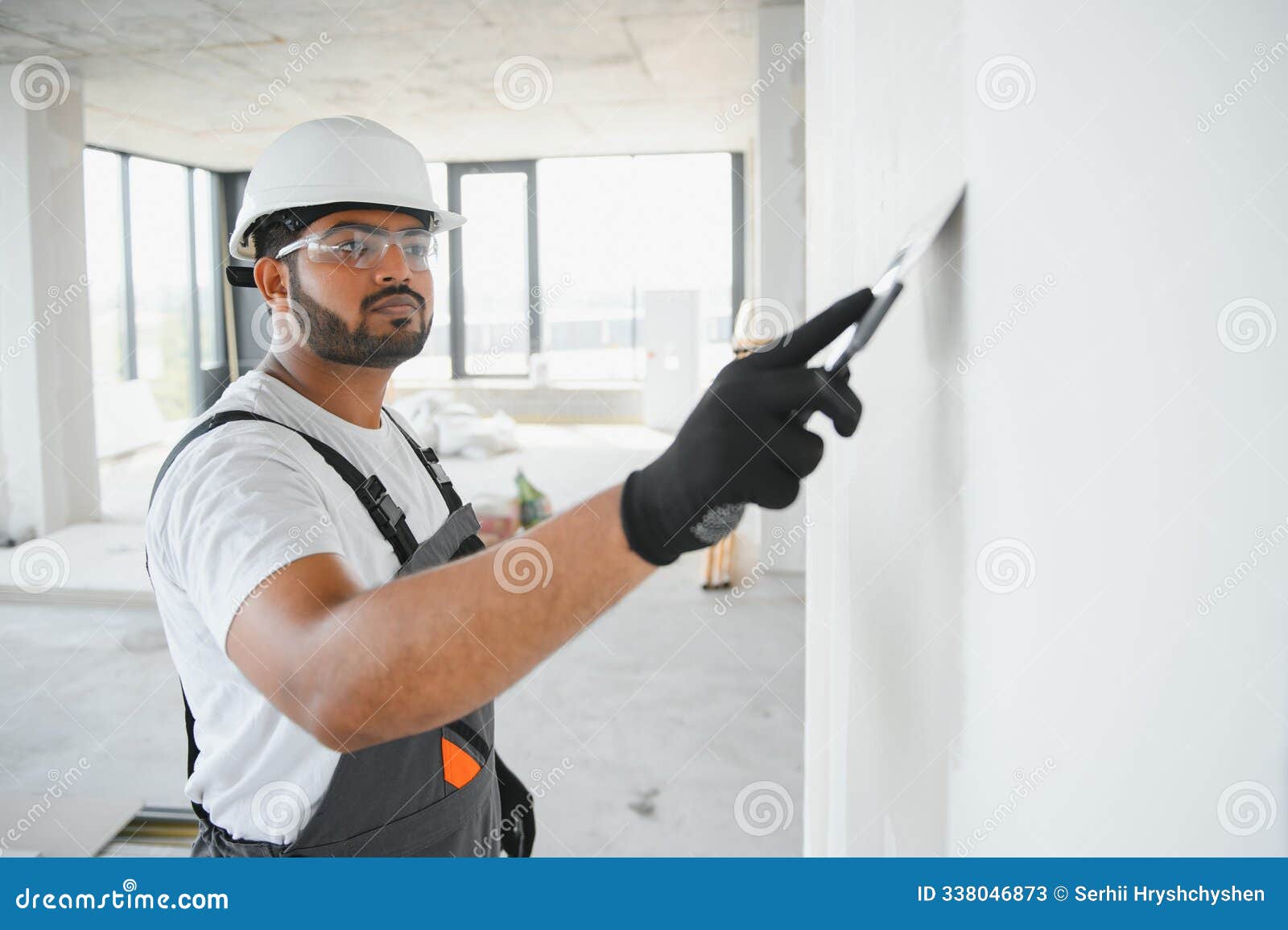 Indian Male Builder in Work Overalls Plastering a Wall Using a ...