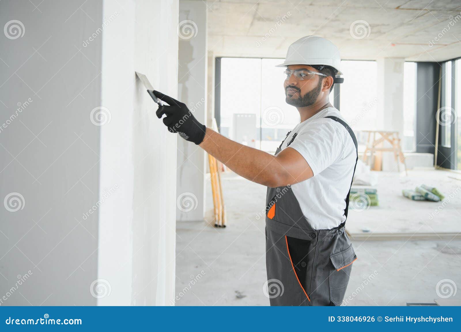 Indian Male Builder in Work Overalls Plastering a Wall Using a ...