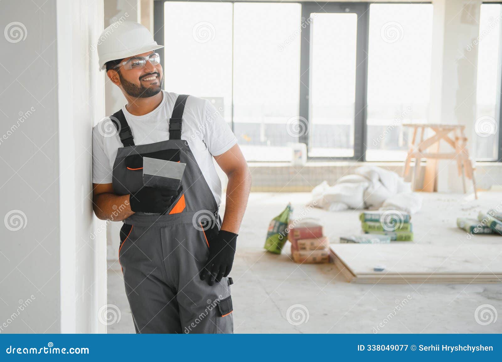 Indian Male Builder in Work Overalls Plastering a Wall Using a ...