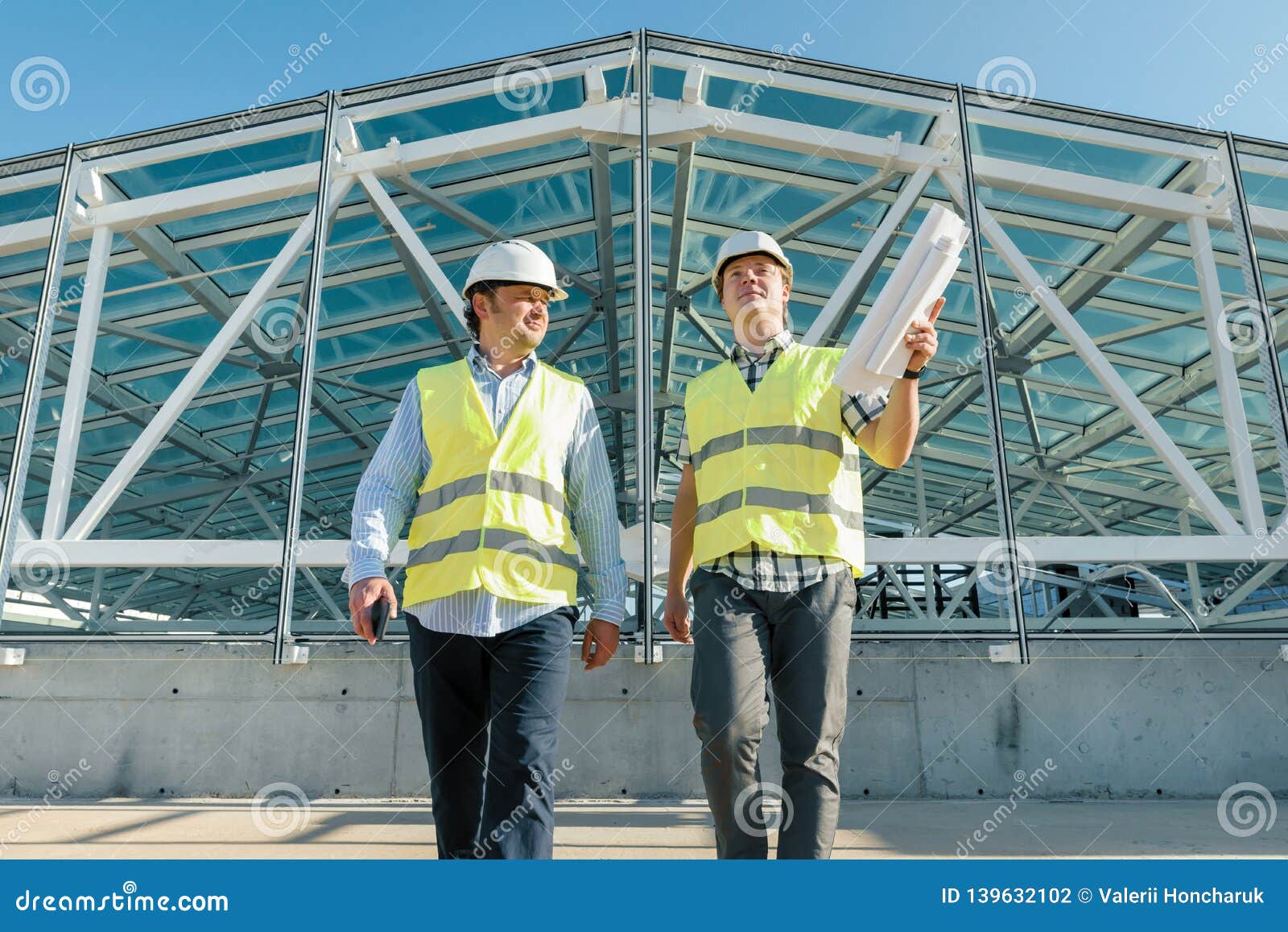 Male Builders Go Forward on Roof of Construction Site. Building ...