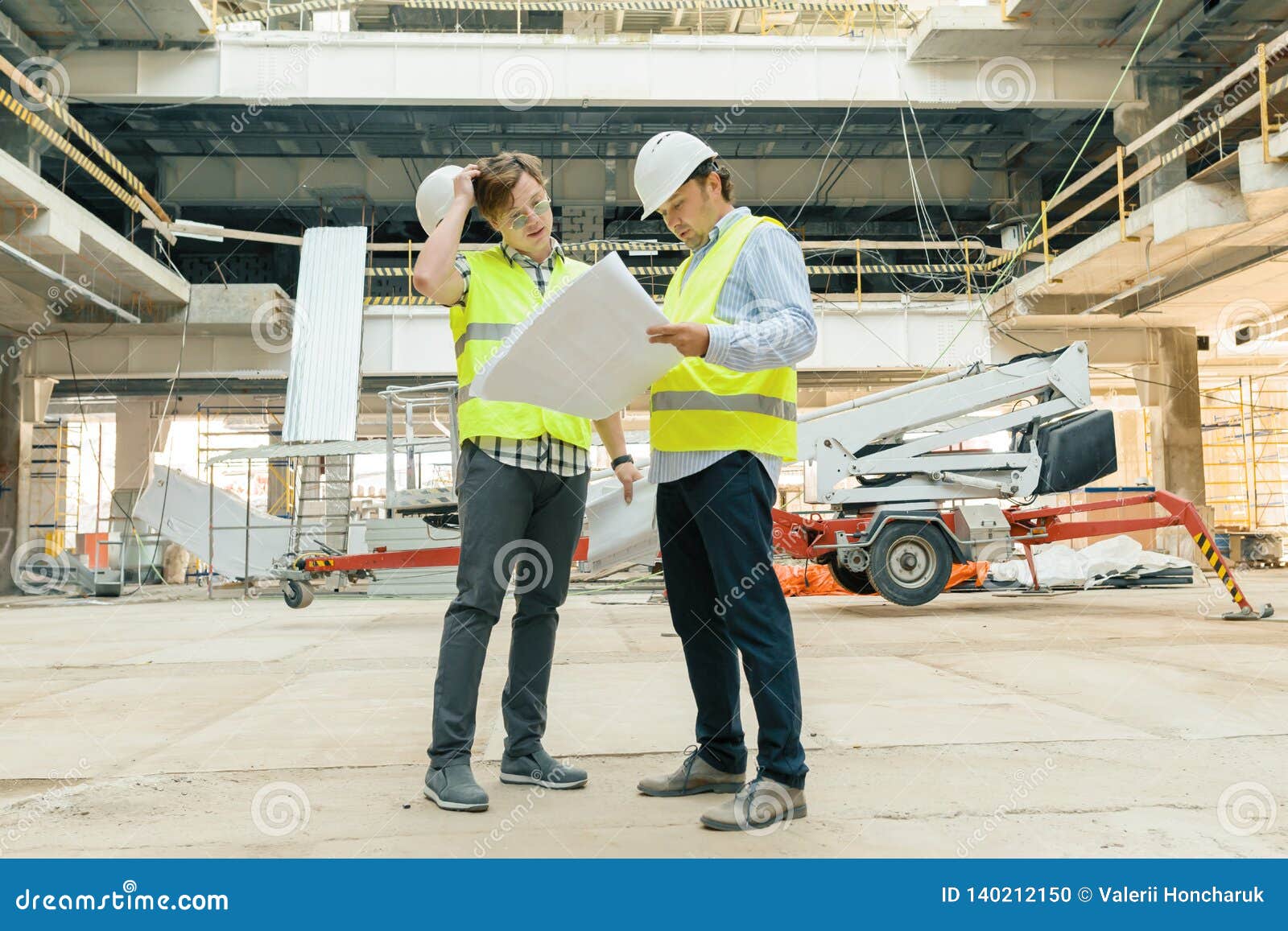 Male Building Workers Working at Construction Site, Builders Looking in ...