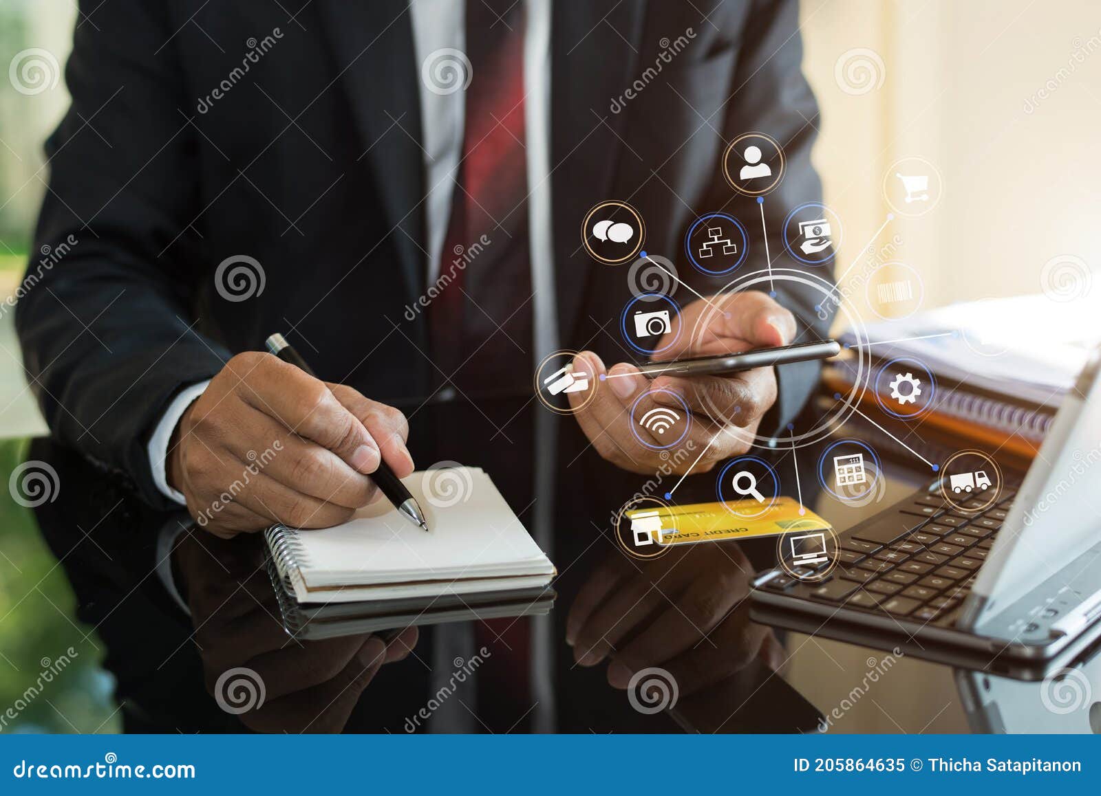 Male Businessman Use Smartphone and Take Notes in the Notebook. Stock ...