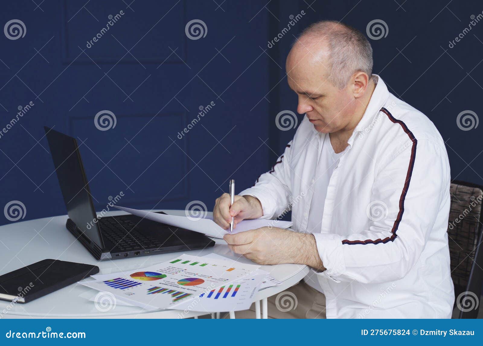 Male Businessman Works on Laptop, Studies Reporting Documents, Charts ...