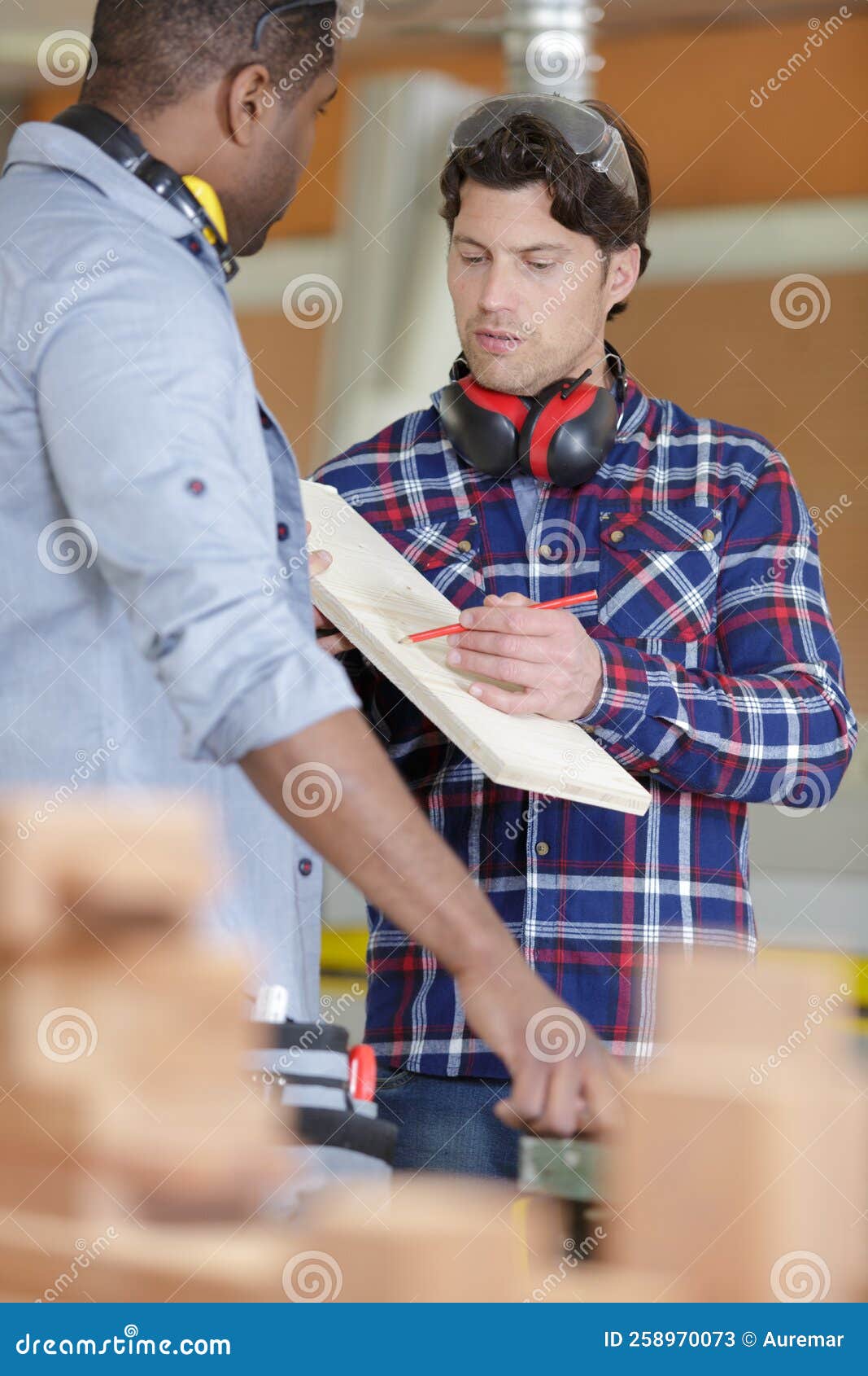 Male Carpenter with Apprentice Measuring Wood Stock Image - Image of ...