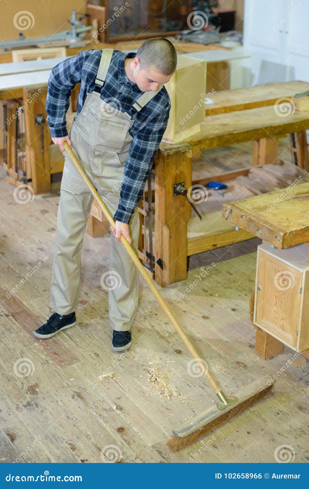 Male Carpenter in Carpentry Workshop Sweeping Sawdust Stock Photo ...