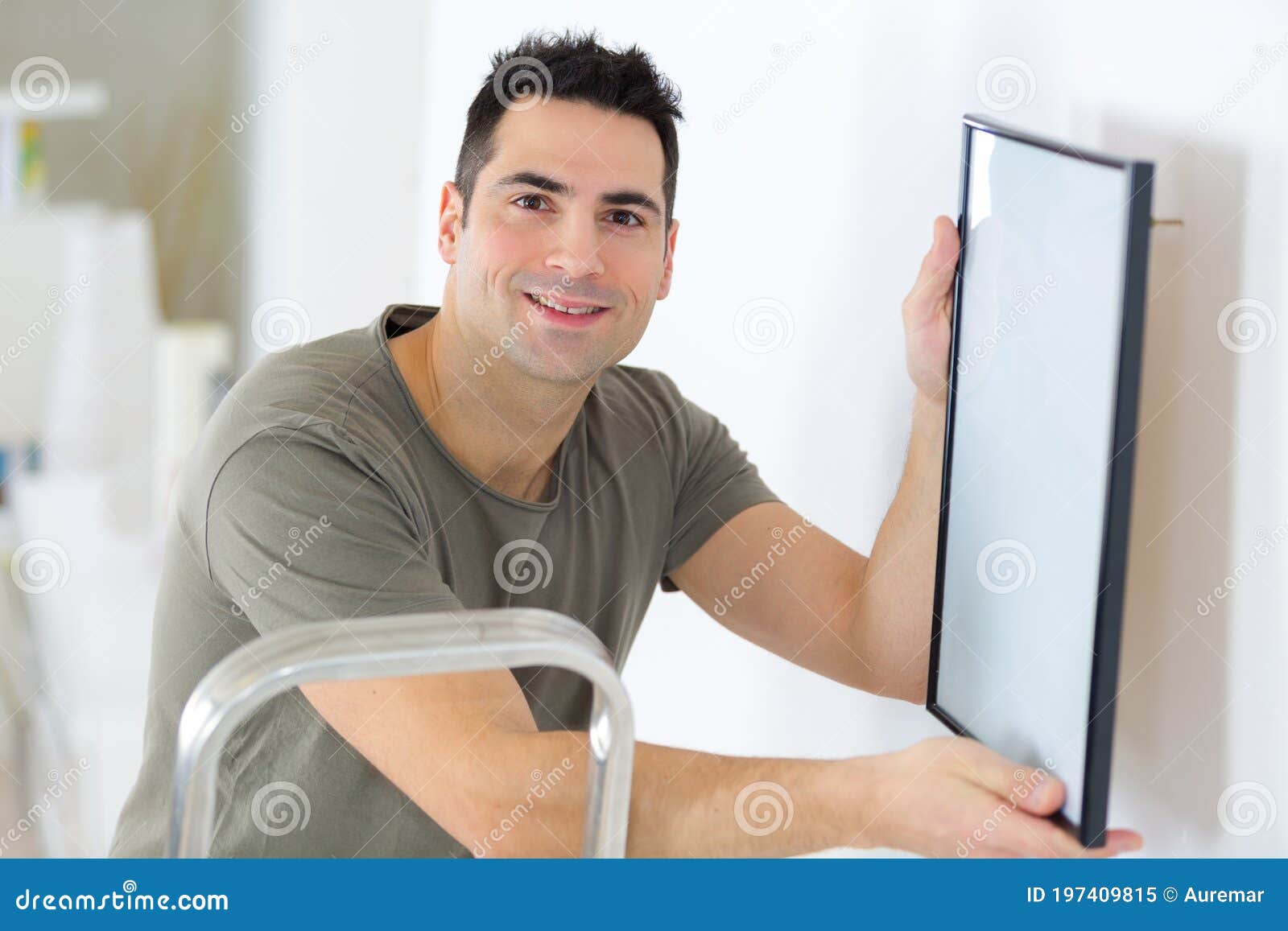 Male Carpenter Hanging Picture Frame on Wall Stock Image - Image of ...