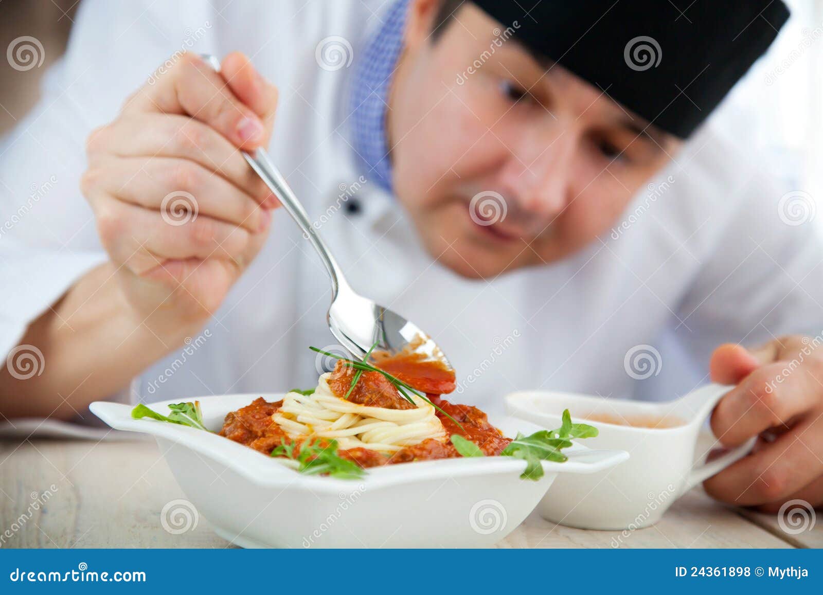 Male Chef Adding Shredded Red Cheddar Cheese On Top Of Dough On A ...